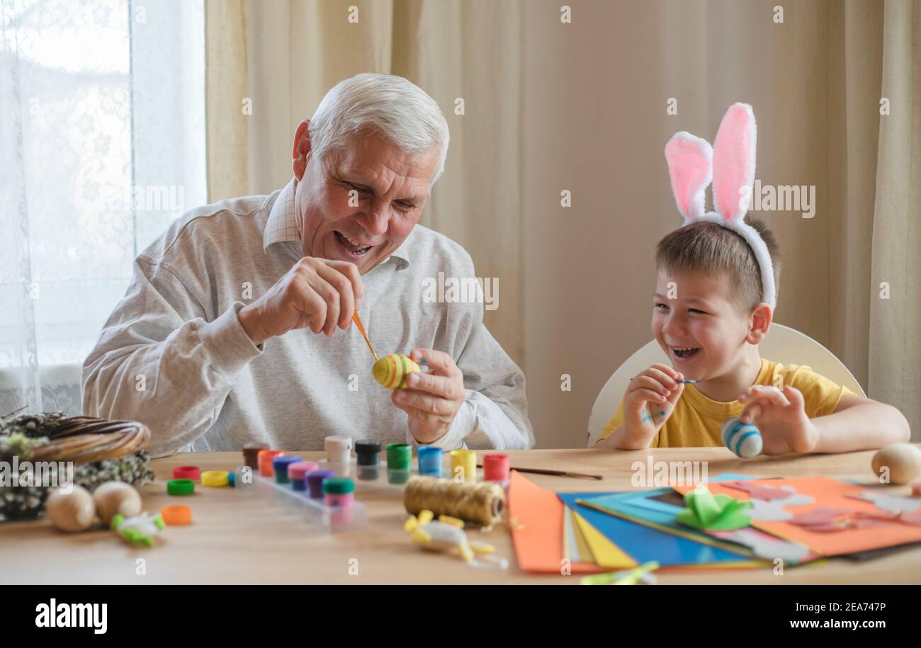 Happy elderly man granfather preparing for Easter with grandson ...