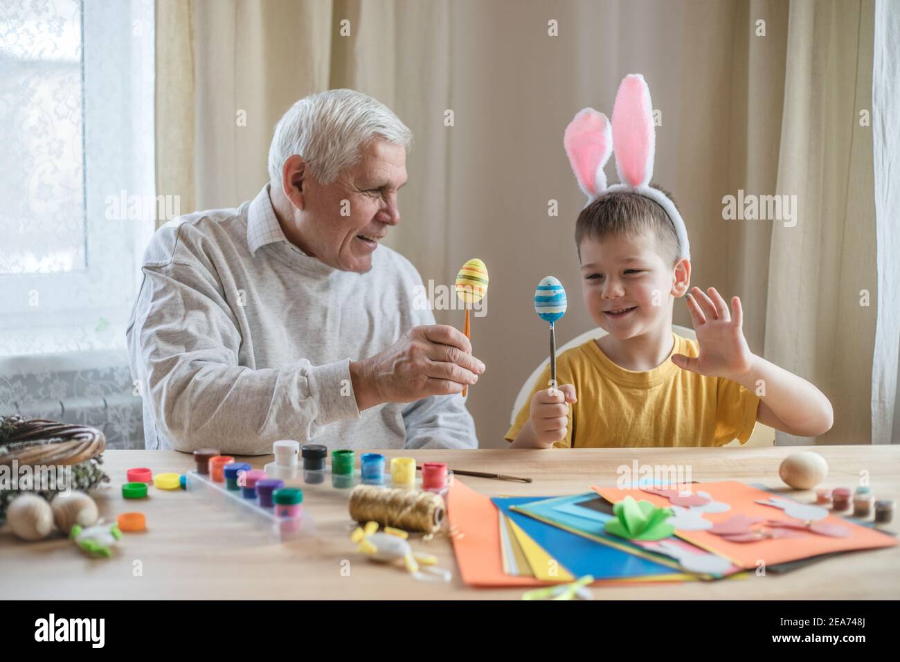 Happy elderly man granfather preparing for Easter with grandson ...