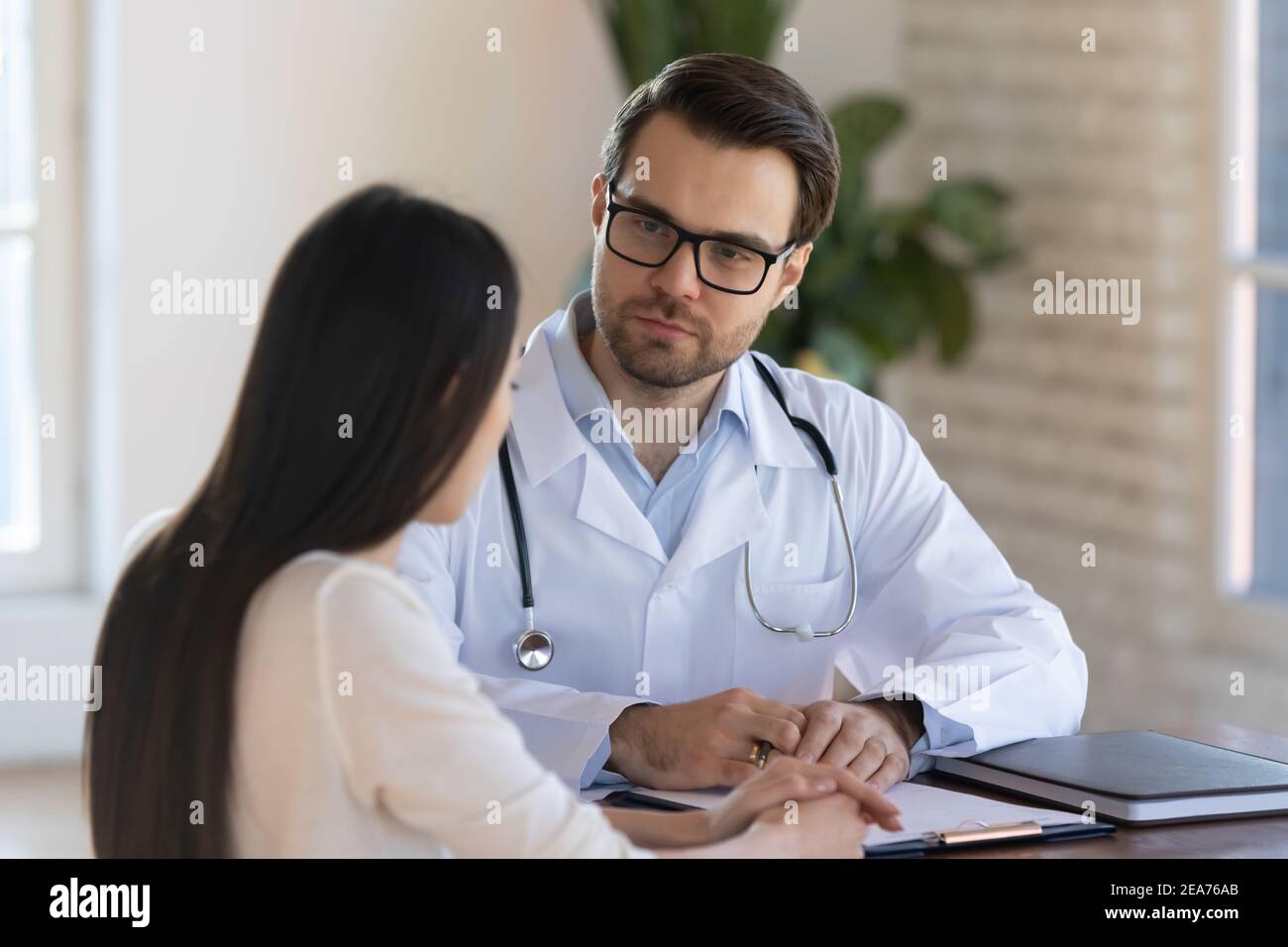 Male doctor listen to female patient complains Stock Photo - Alamy