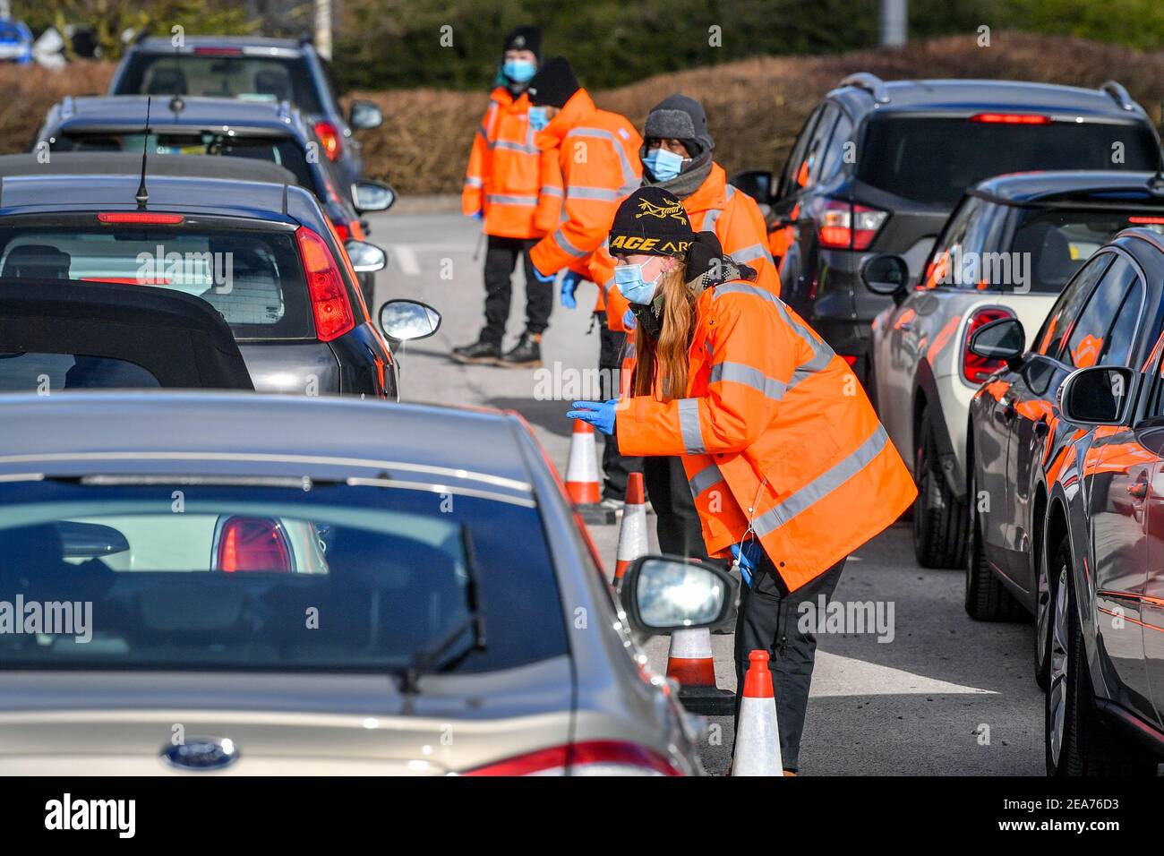 Testing staff hand out kits to motorists attending a surge testing ...