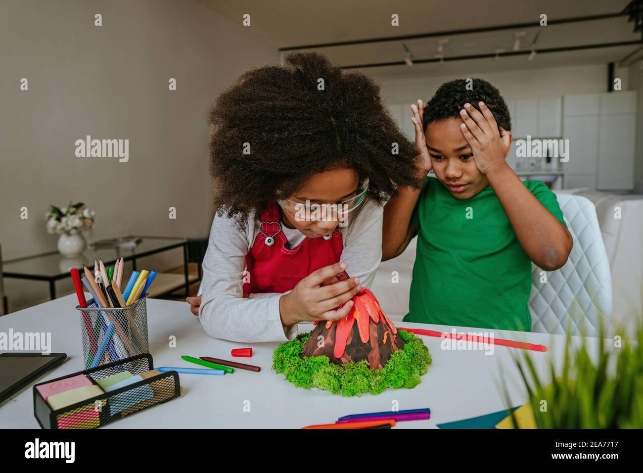 Sister and brother having fun making DIY volcano model from kids play ...