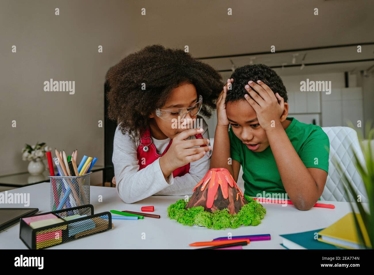 Sister and brother having fun making DIY volcano model from kids play ...