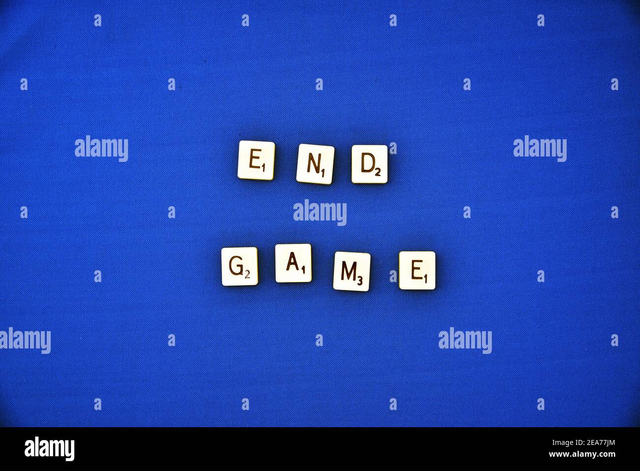 Scrabble tiles on blue background spelling End Game Stock Photo - Alamy