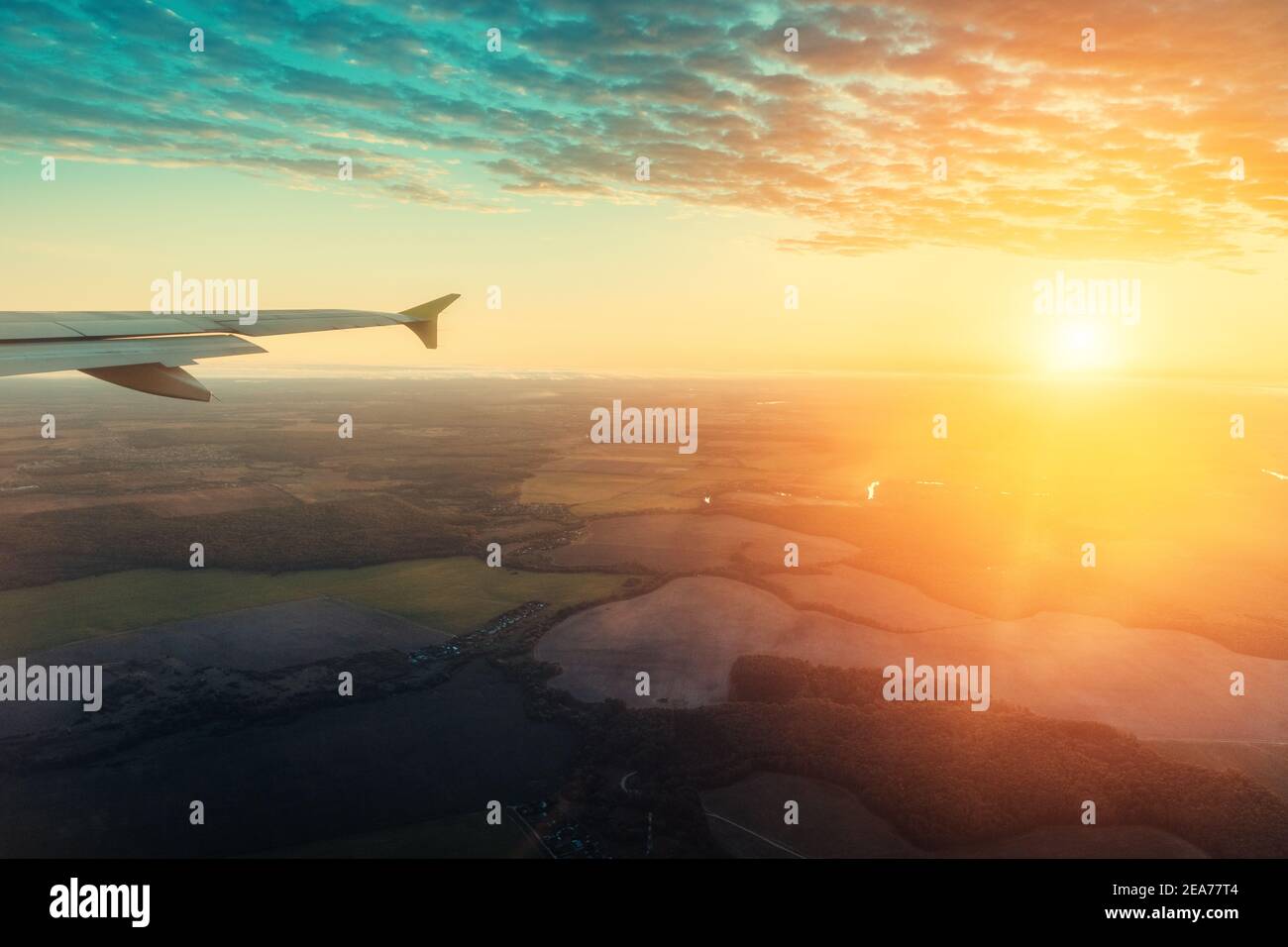 Colorful and picturesque sunset from the plane window during the flight ...