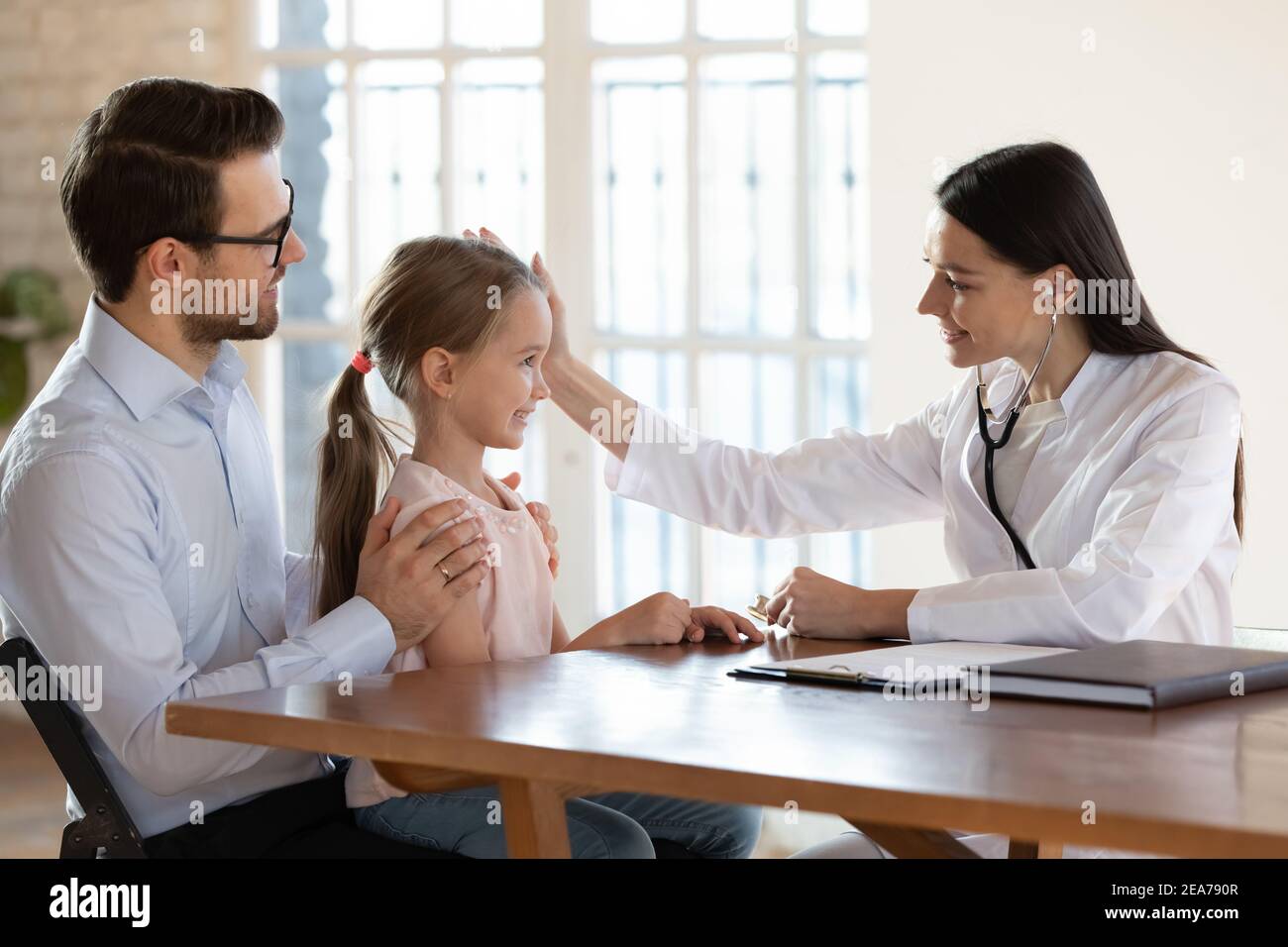 Caring female doctor cheer small girl child patient Stock Photo - Alamy