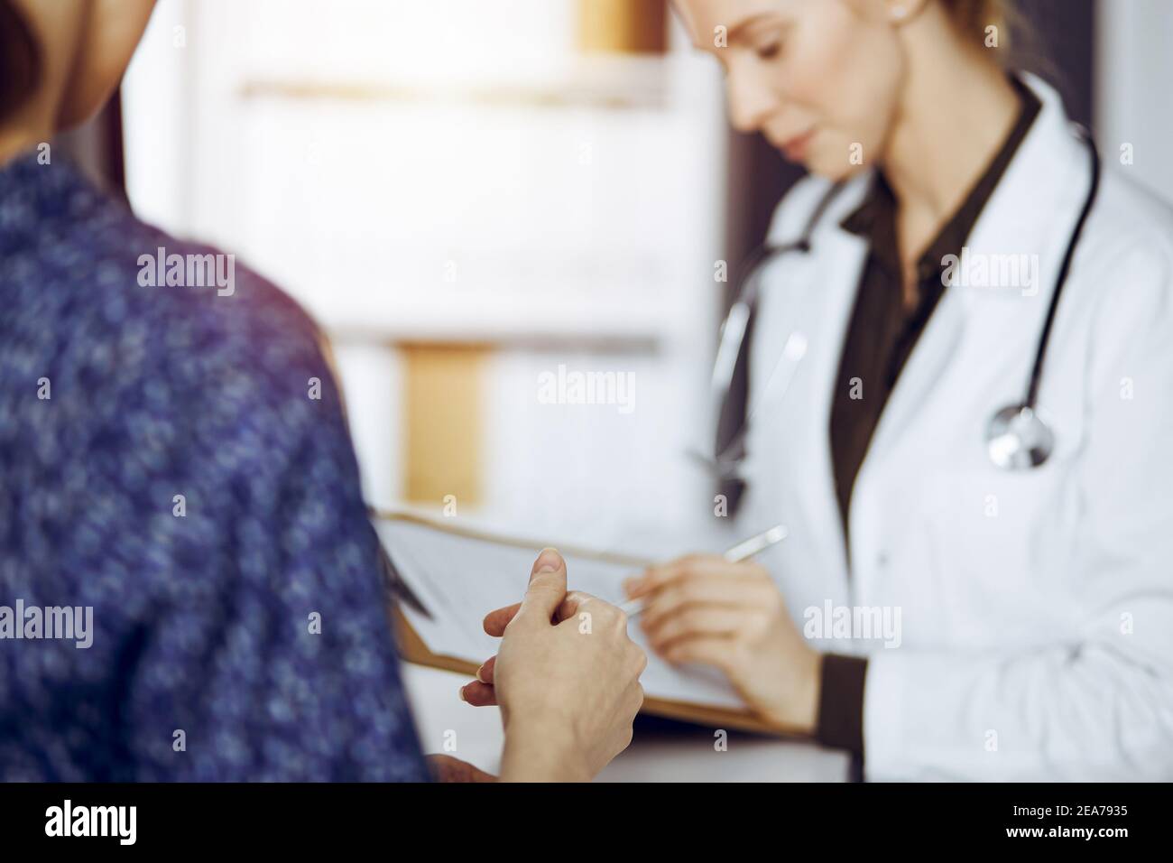 Doctor and patient discussing current health examination while sitting ...