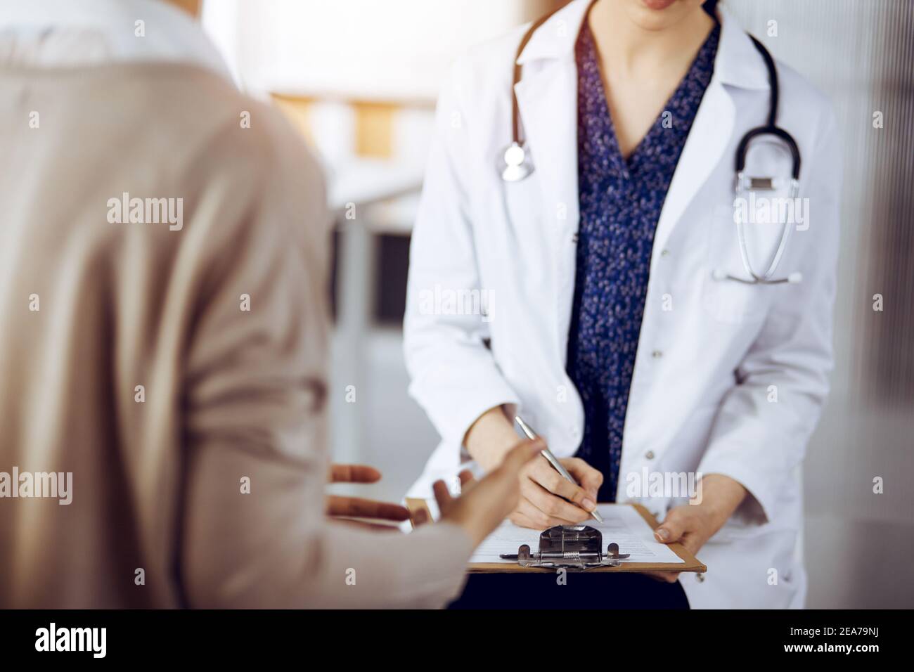 Doctor and patient discussing current health examination while sitting ...