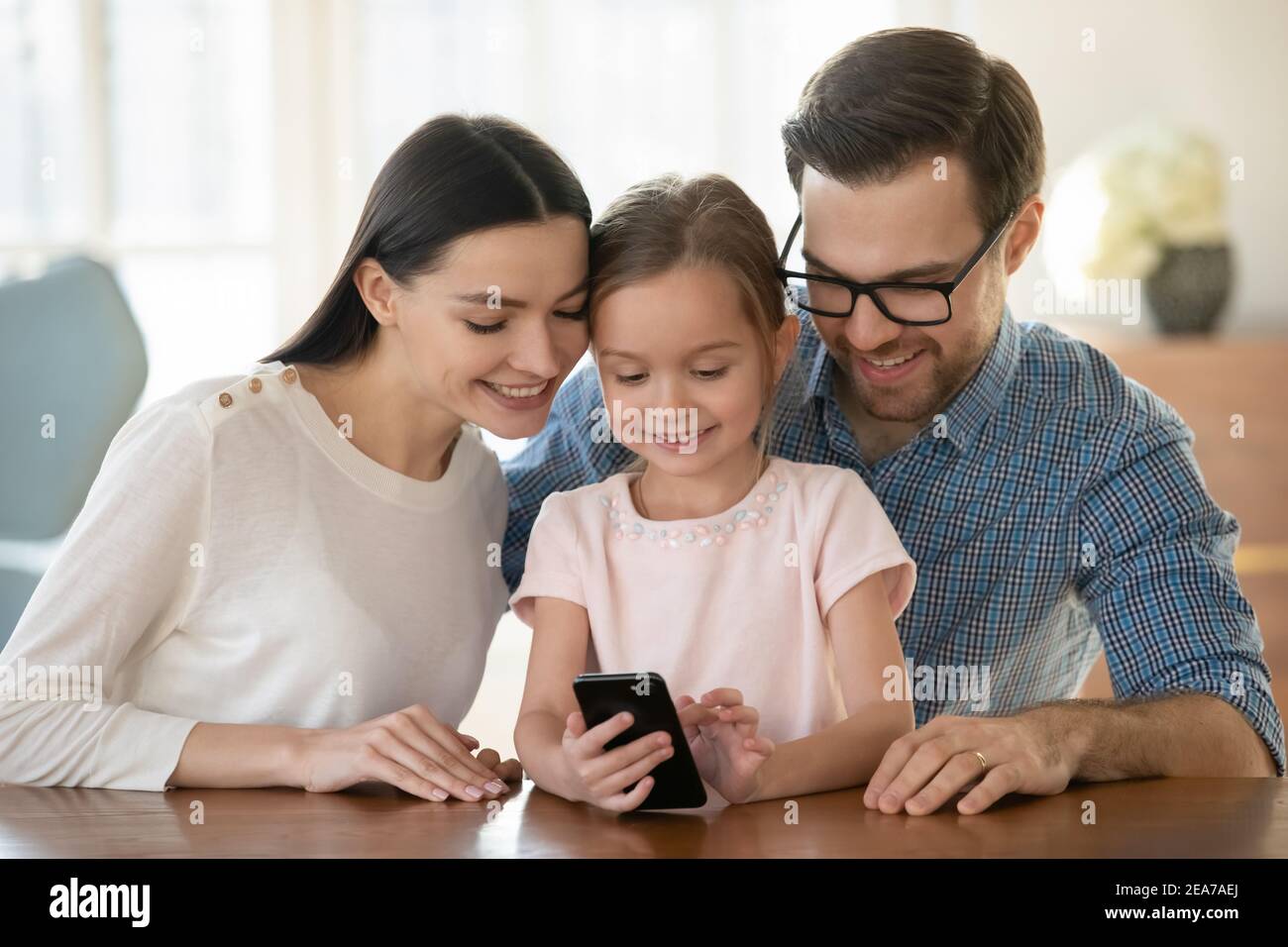Happy family with little kid use smartphone together Stock Photo - Alamy