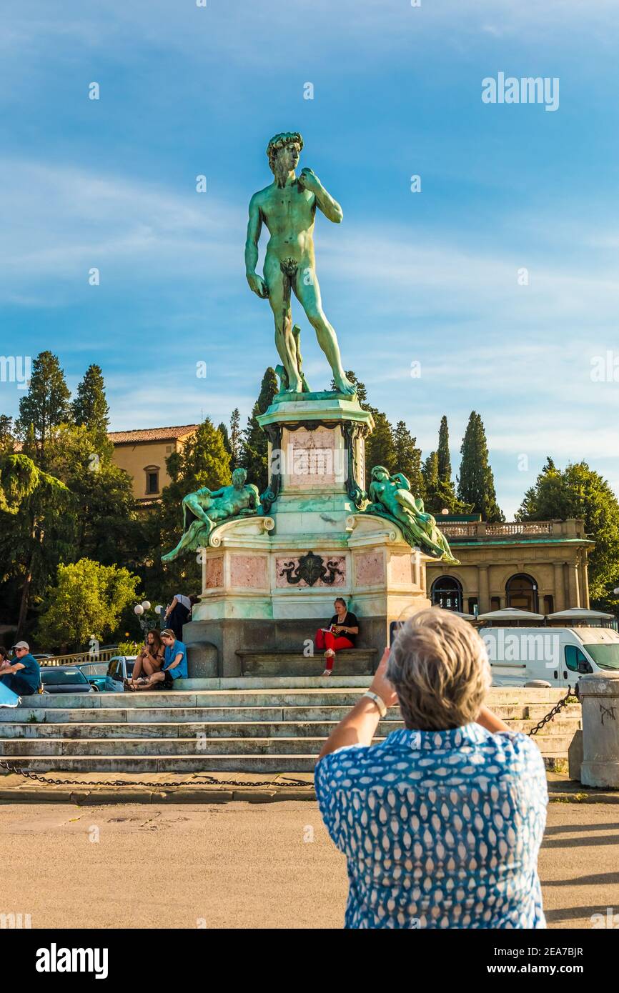 A tourist is taking photos of the bronze cast of David, a copy of ...
