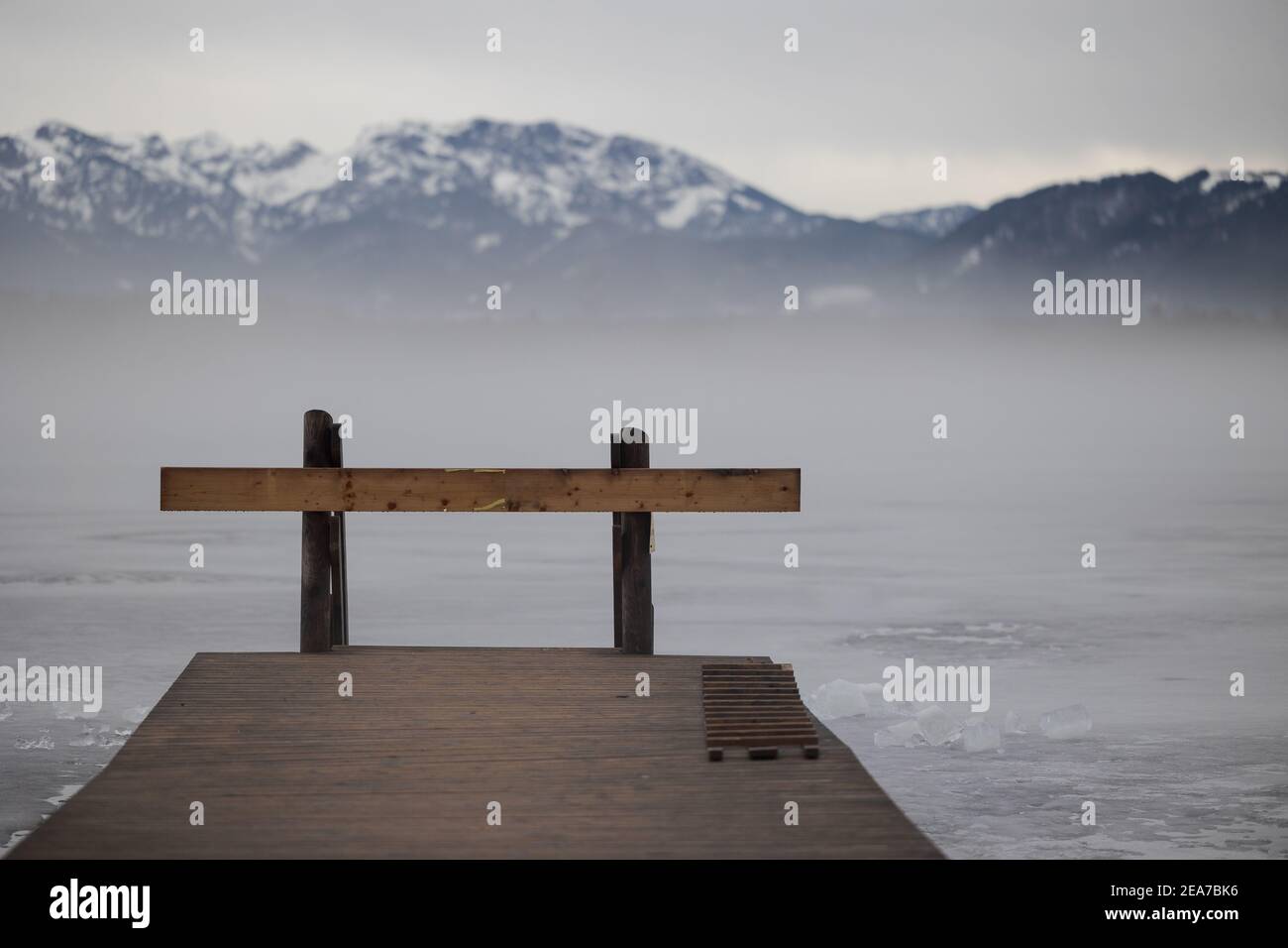 Barred wooden nose-piece on frozen lake in Upper Bavaria with Alps in ...