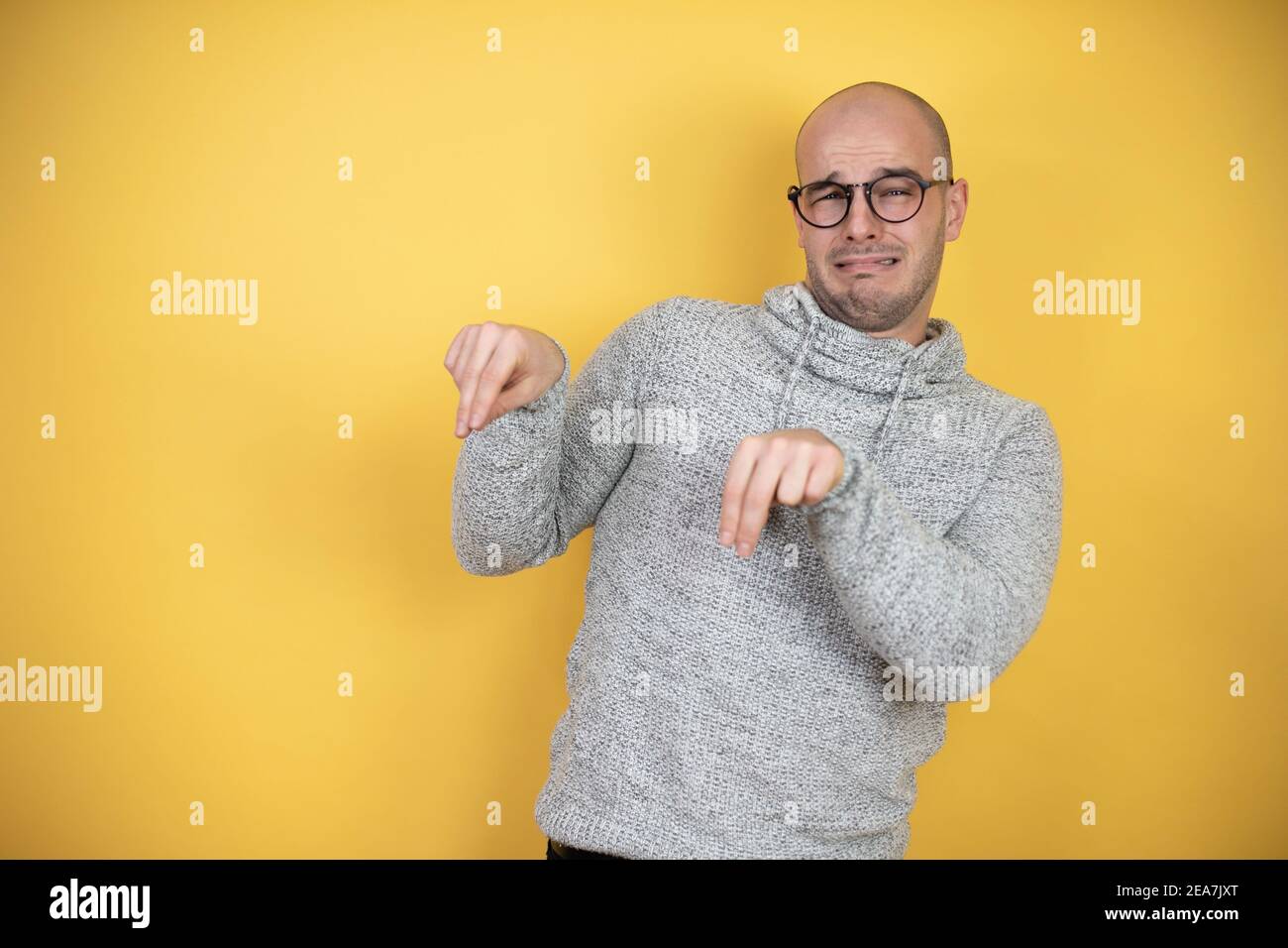 Young bald man wearing glasses over yellow background disgusted ...