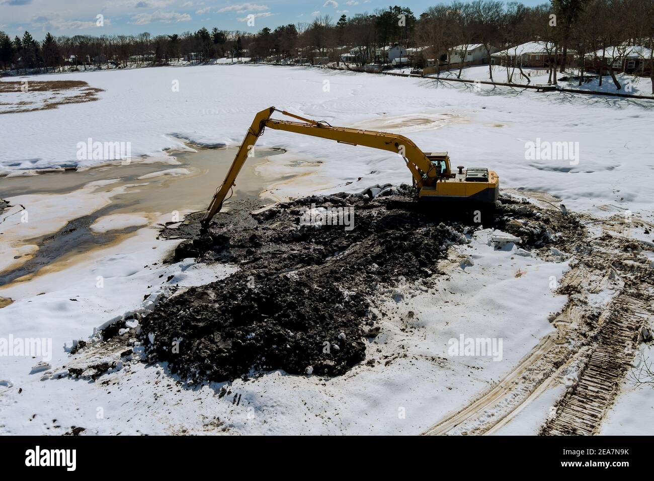Cleaning the bottom of the lake a excavator bucket is soak in water ...