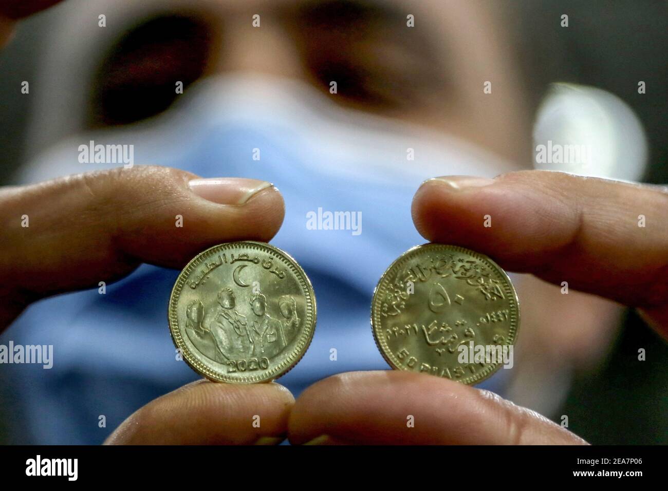 Cairo, Egypt. 08th Feb, 2021. A worker holds two Egyptian 50pt coins at ...