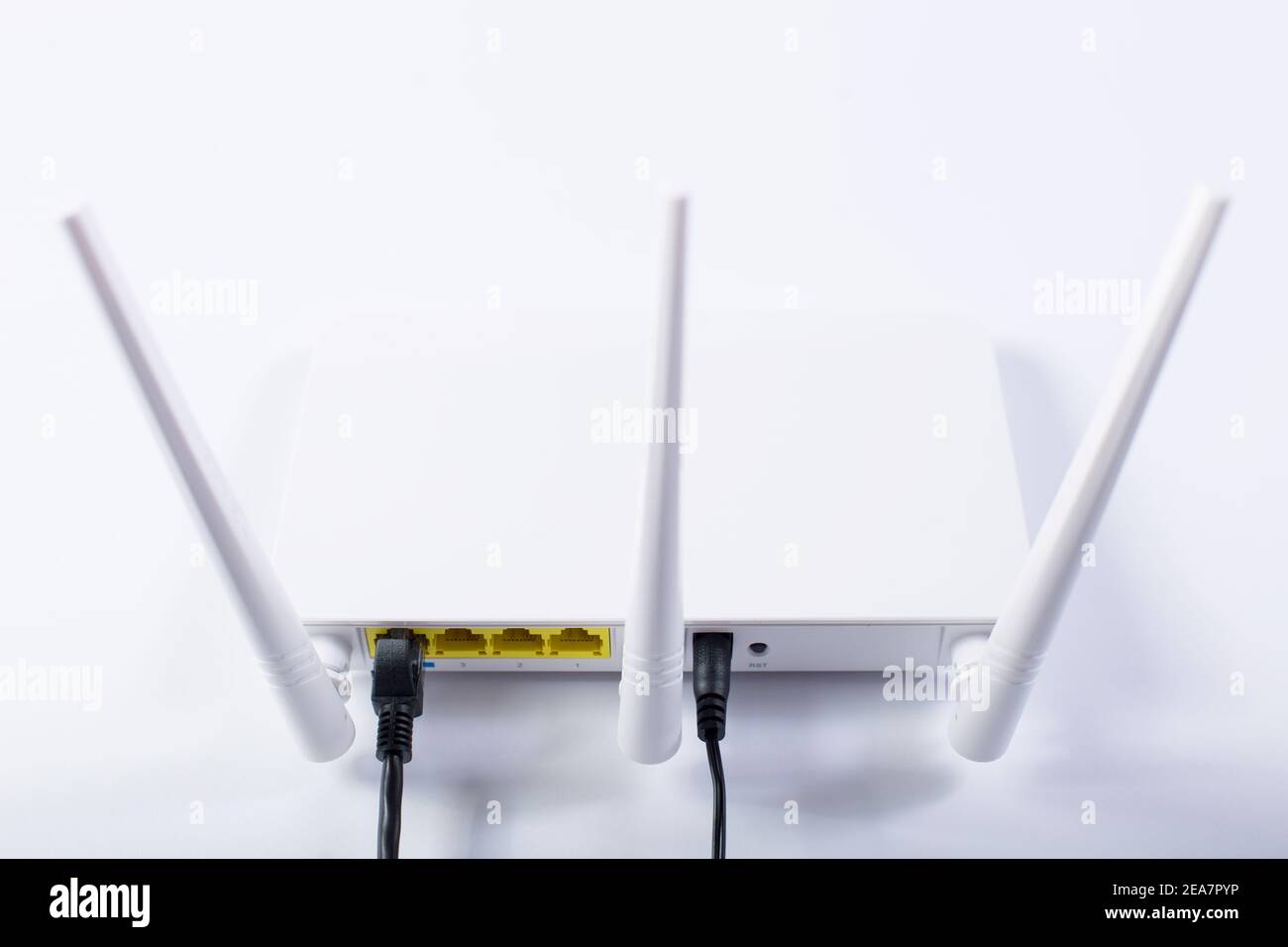 White wifi router with three antennas connecteed to network, on a white ...