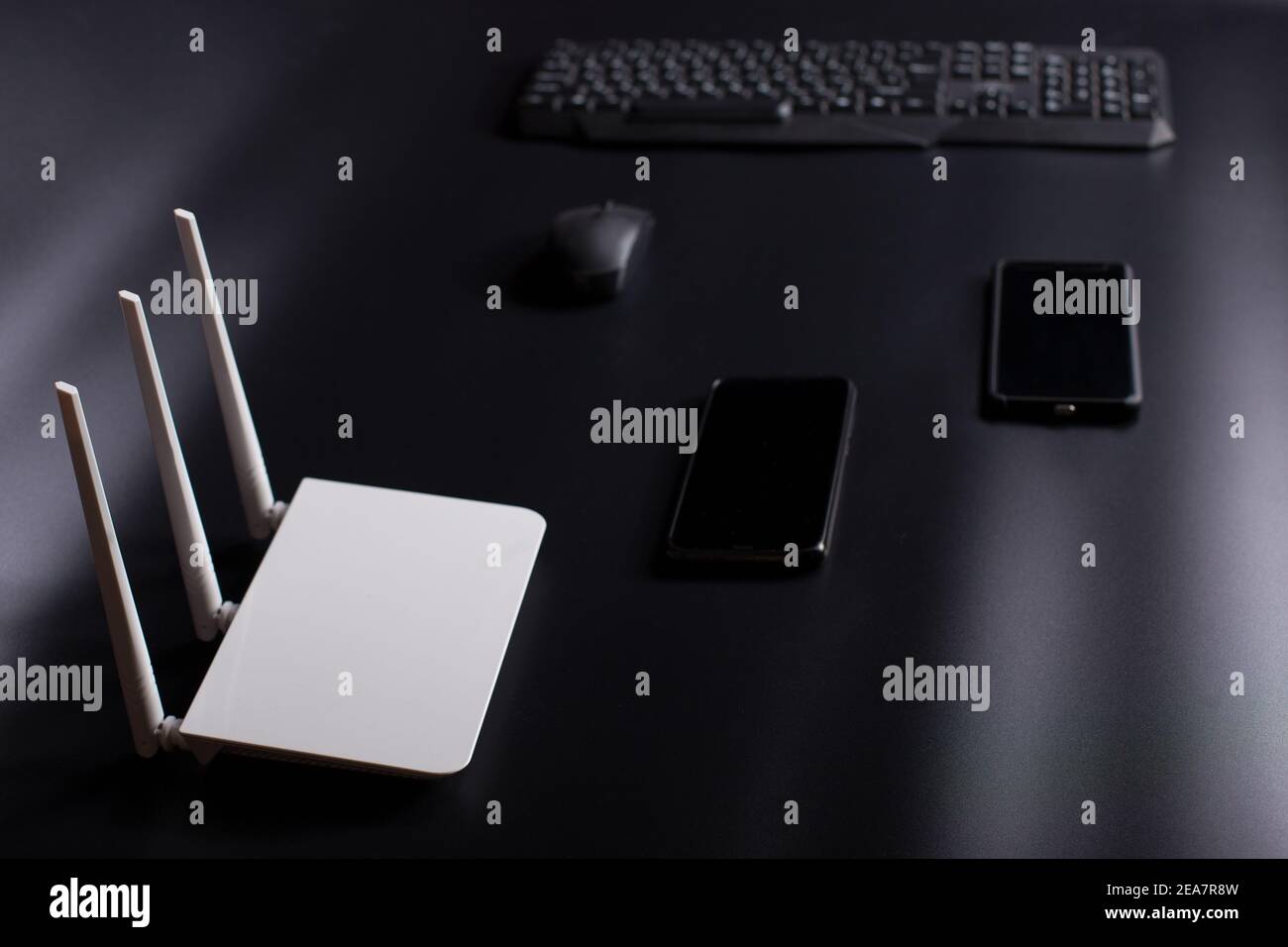 White wifi router with many gadgets on black background. Wi-fi network ...