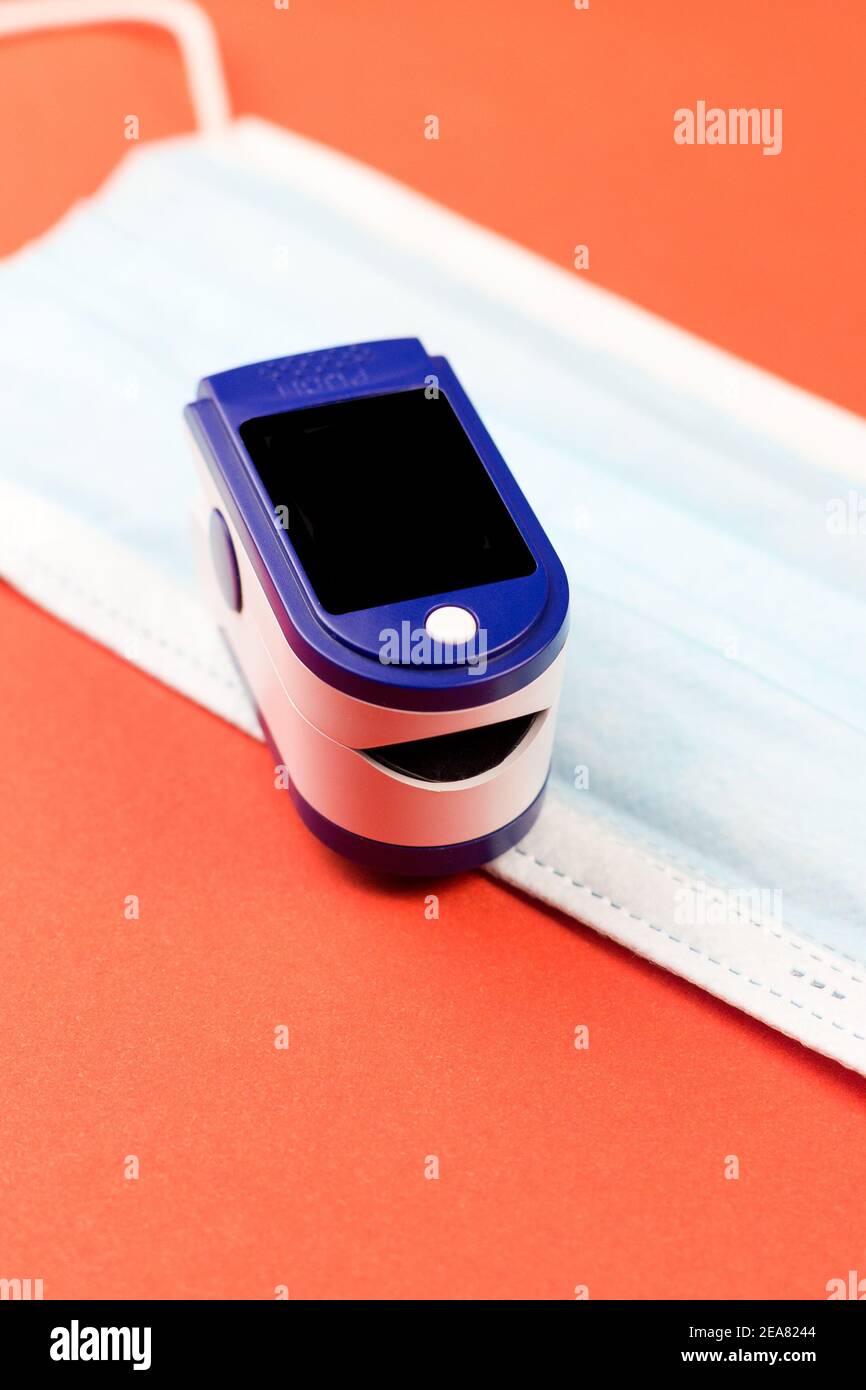 Pulse oximeter and protective medical mask orange background Stock ...