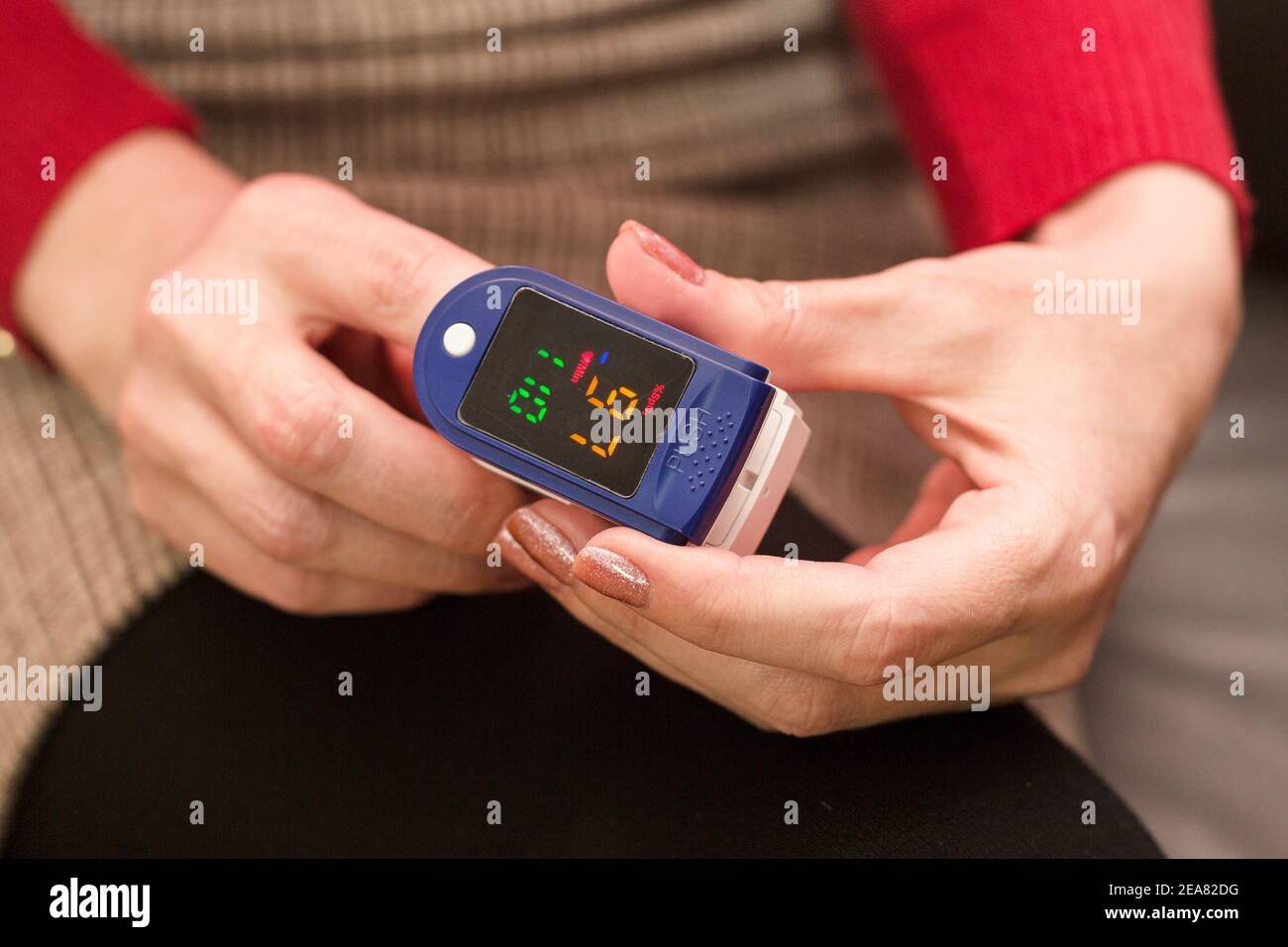 Woman measuring her blood oxygen level while sitting sofa at home Stock ...