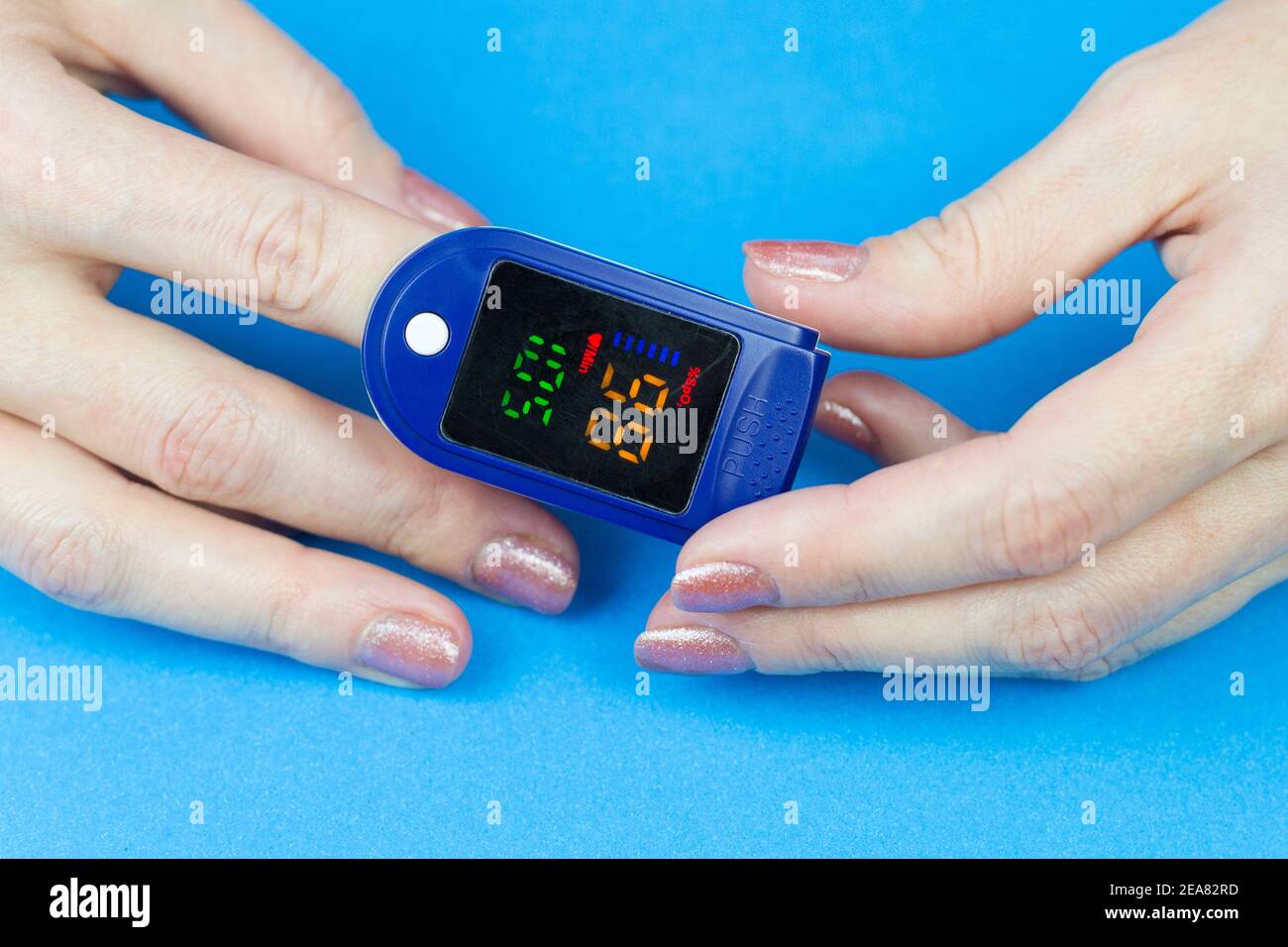 Oximeter on the finger of a woman's hand reading oxygen in human blood ...