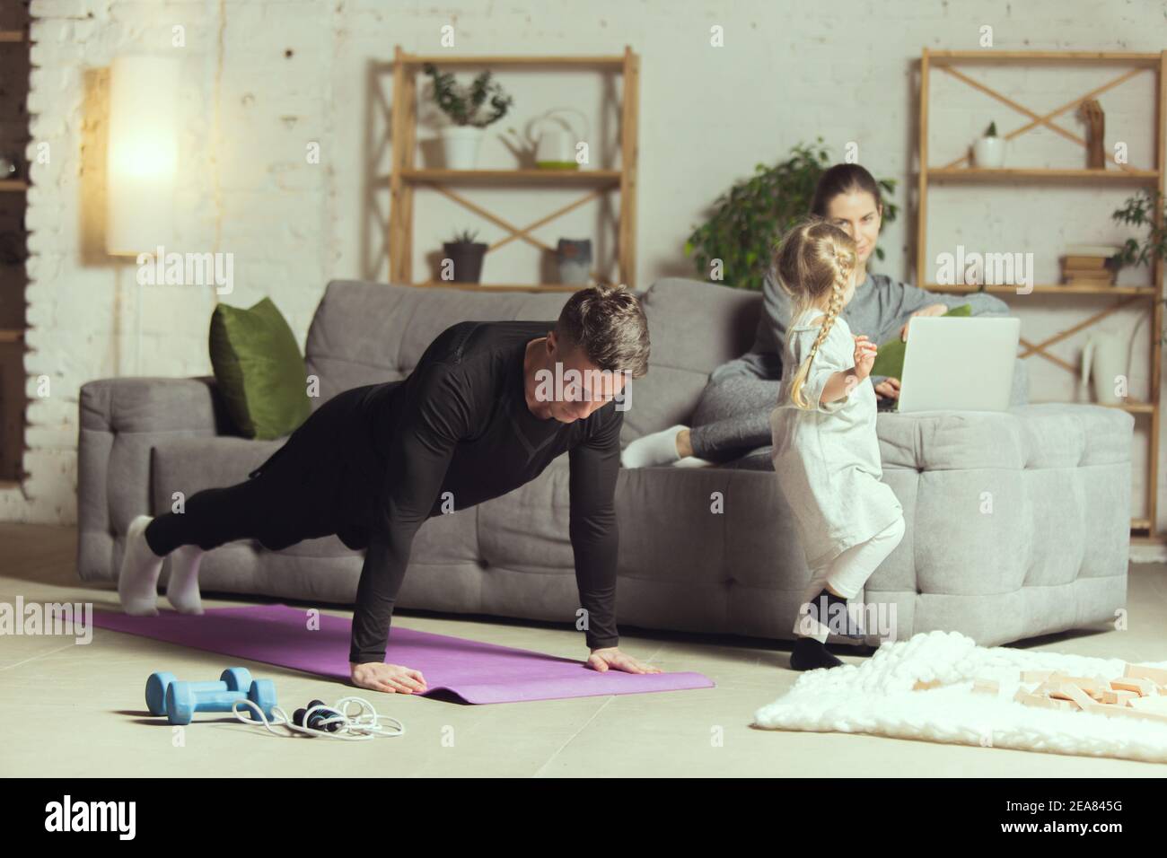 Pushes up. Young man exercising fitness, aerobic, yoga at home, sporty ...