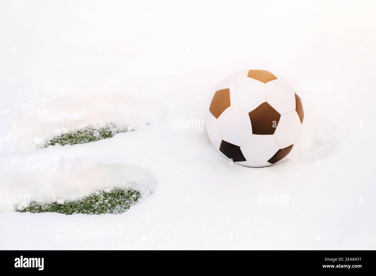 Soccer ball on a snowy sports field and footprints in the snow Stock ...