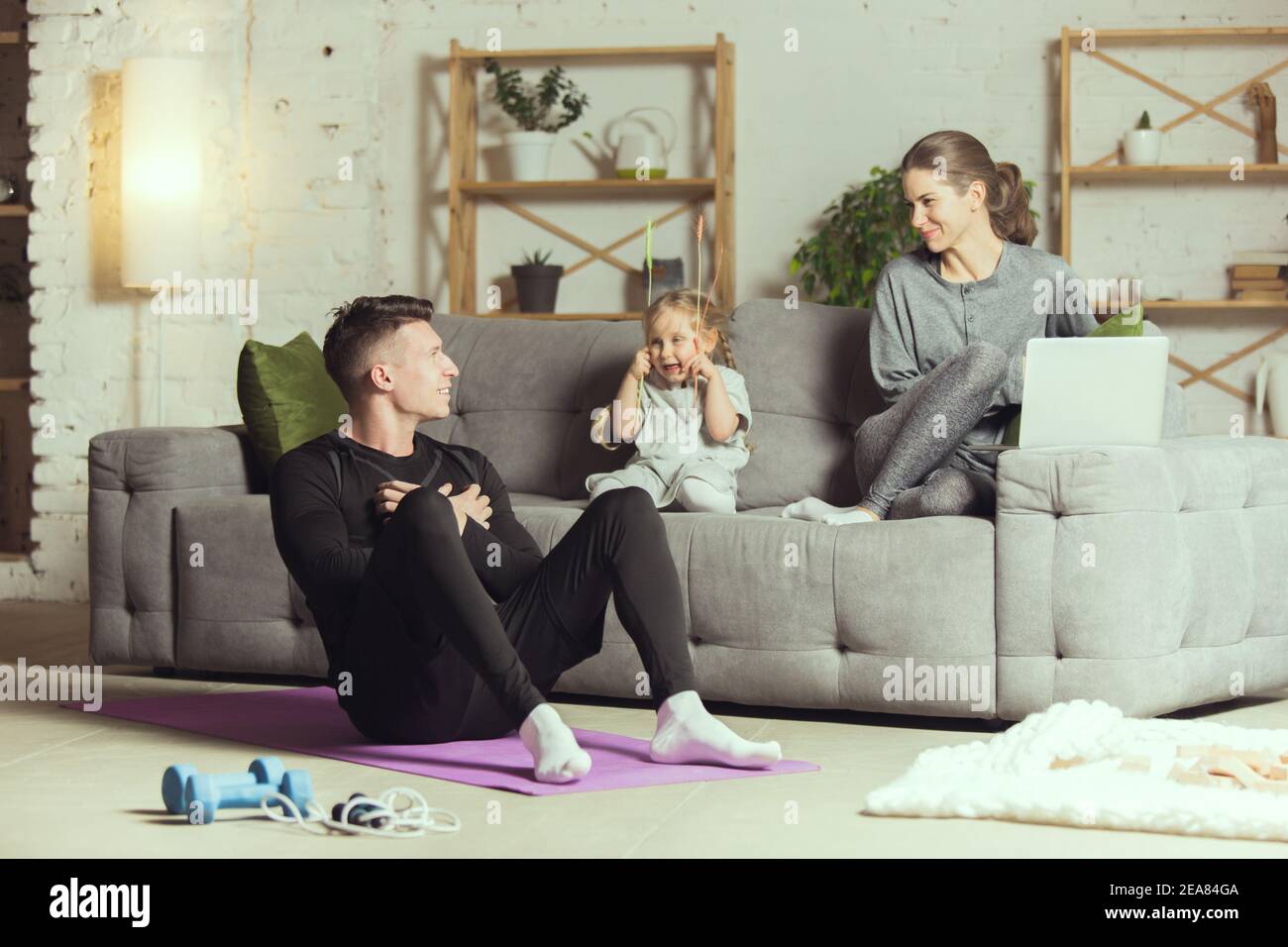 Happy and cheerful. Young family resting after exercising fitness ...