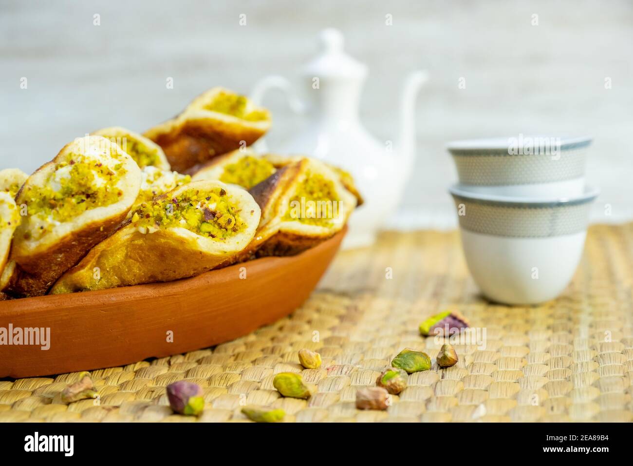 Ramadan sweets qatayef with white background and arabian coffee cups ...