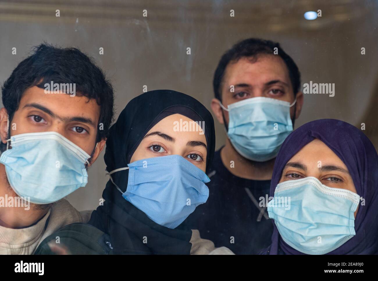 Arabic family looking from the window during the quarantine time and ...