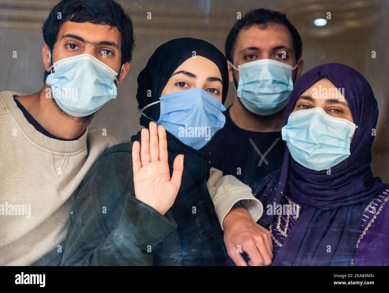 Arabic family looking from the window during the quarantine time and ...