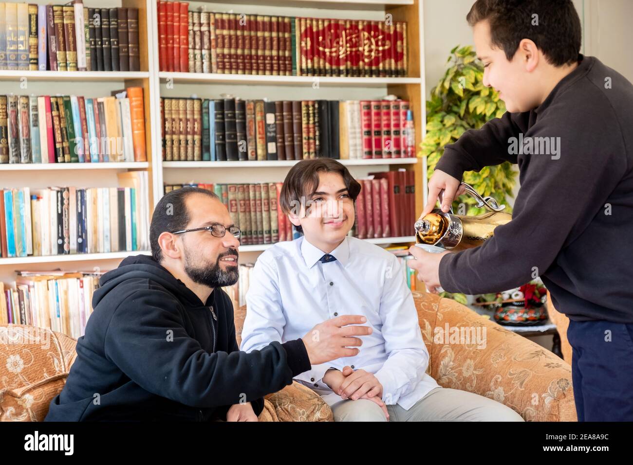 Family enjoy the eid celebration and serving guests Stock Photo - Alamy