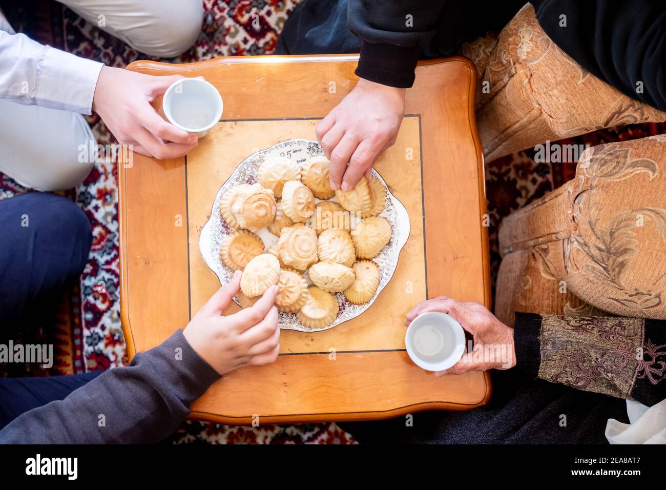 Arabic family eating sweets together and drinking coffee Stock Photo ...