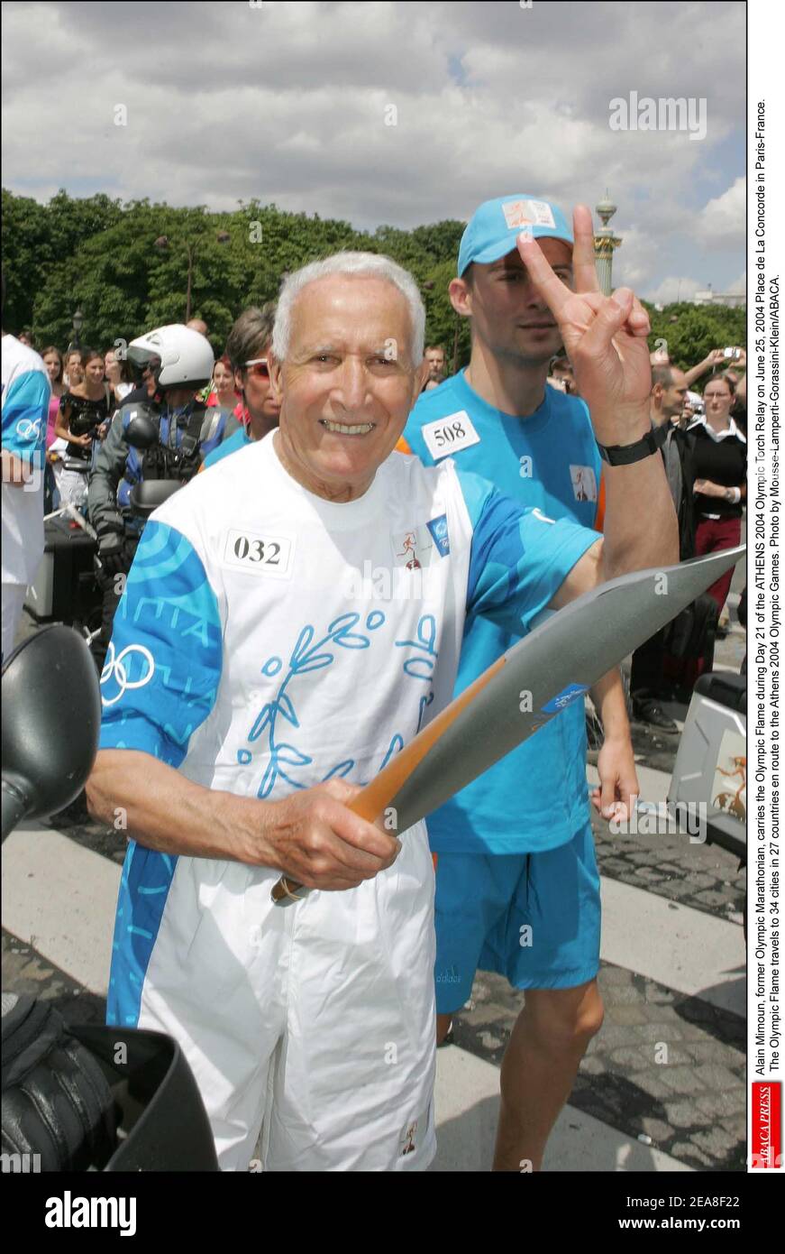 Alain Mimoun, former Olympic Marathonian, carries the Olympic Flame ...