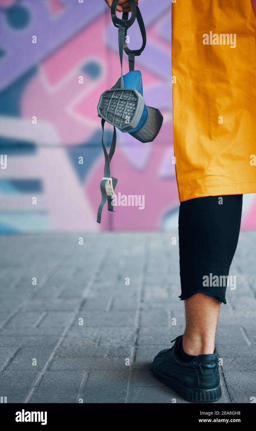 Cropped image of street artist with respirator mask in hand standing ...