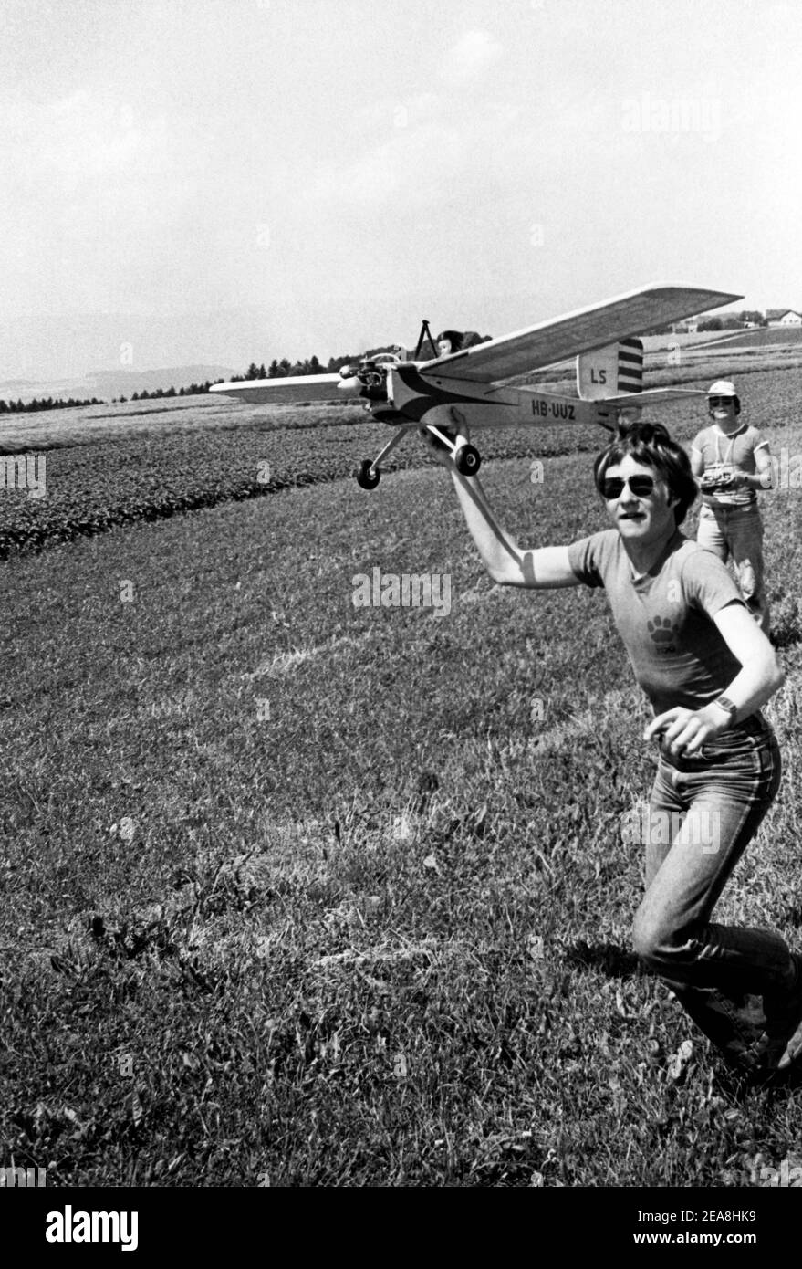 TWO GUYS FLYING with a model plane on a field Stock Photo - Alamy