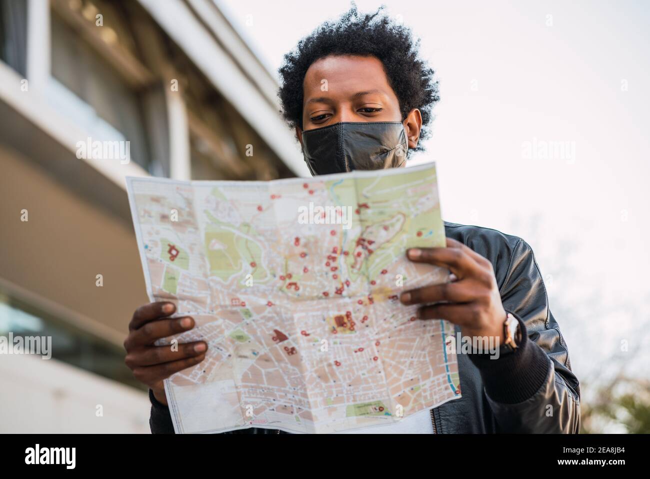 Tourist man looking for directions on map Stock Photo - Alamy