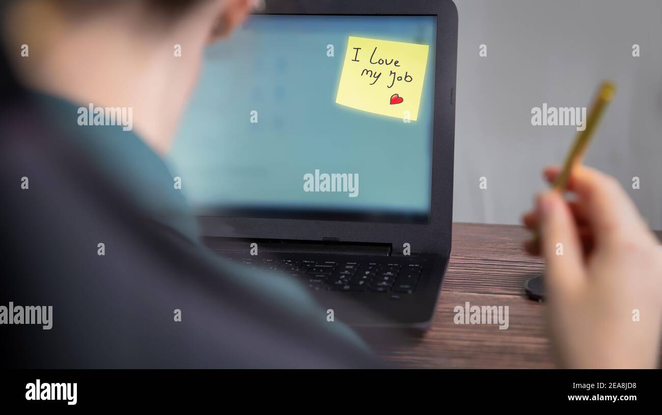 Business woman sitting in her home office with laptop and sticky note ...
