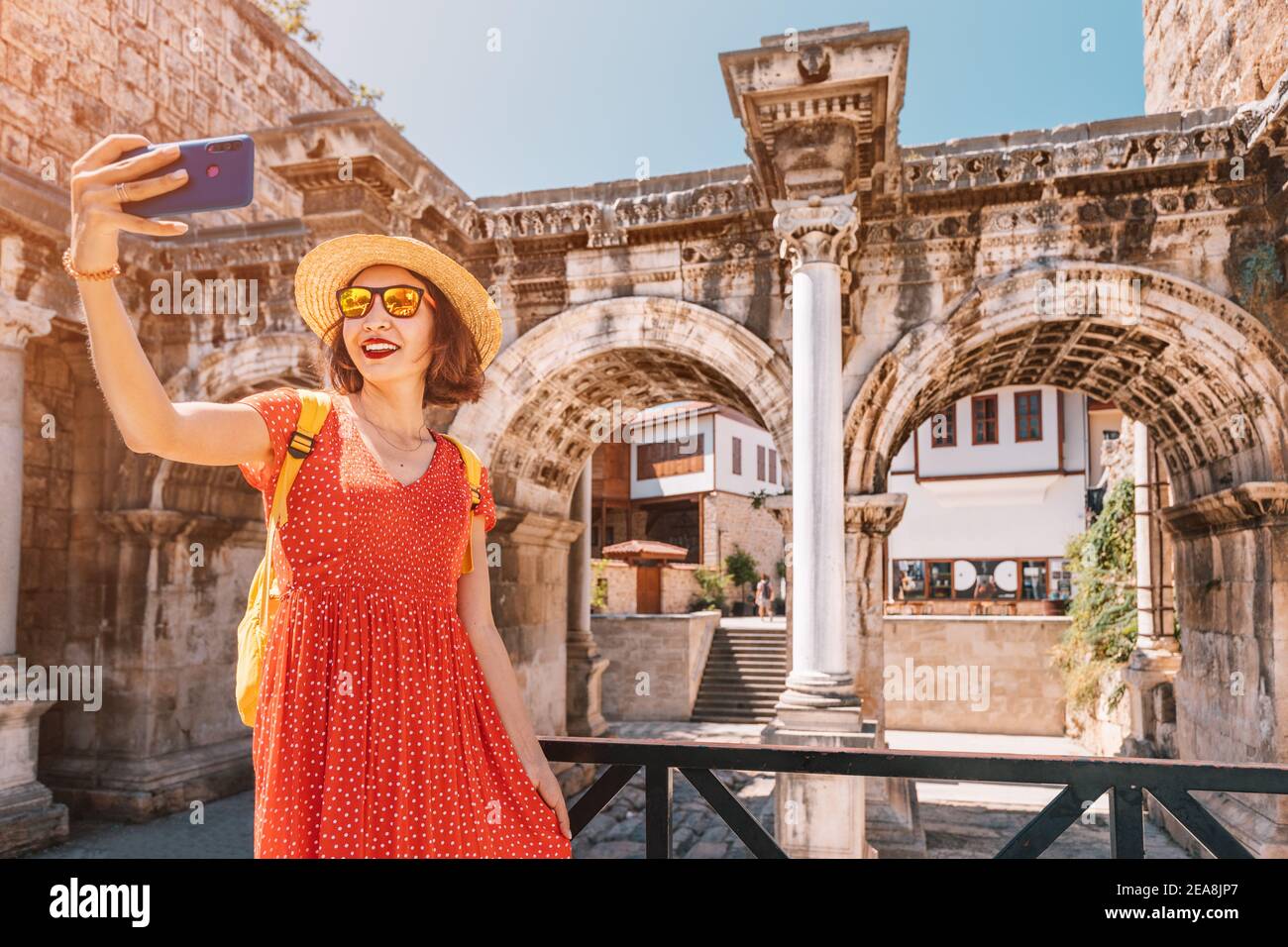 Happy female tourist traveller takes selfie photos against the backdrop ...