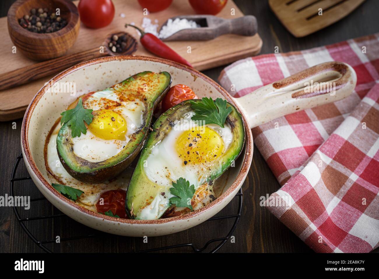 Avocado baked with egg on ceramic serving pan Stock Photo - Alamy