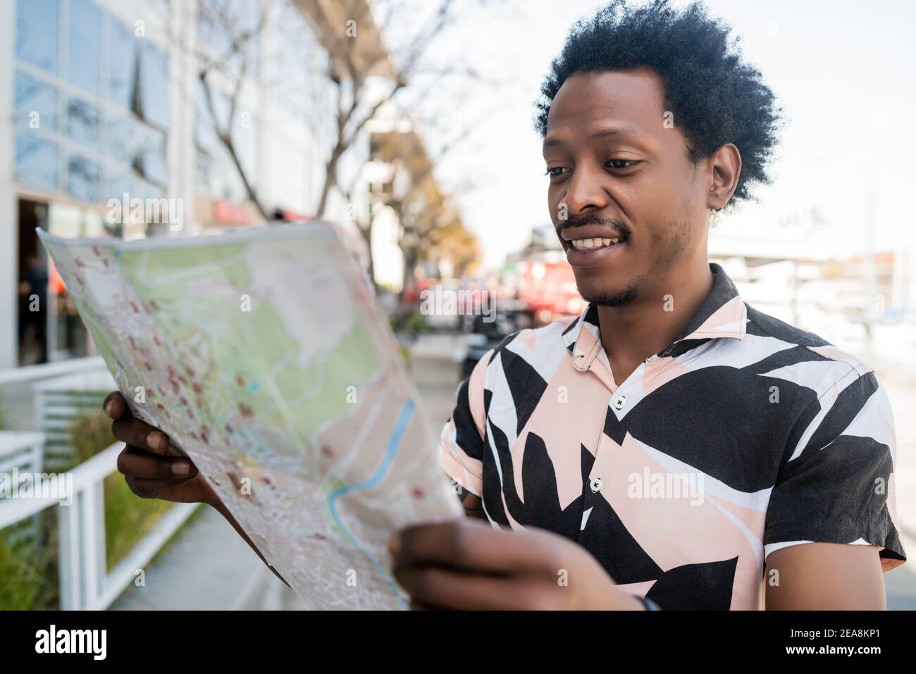 Tourist man looking for directions on map Stock Photo - Alamy
