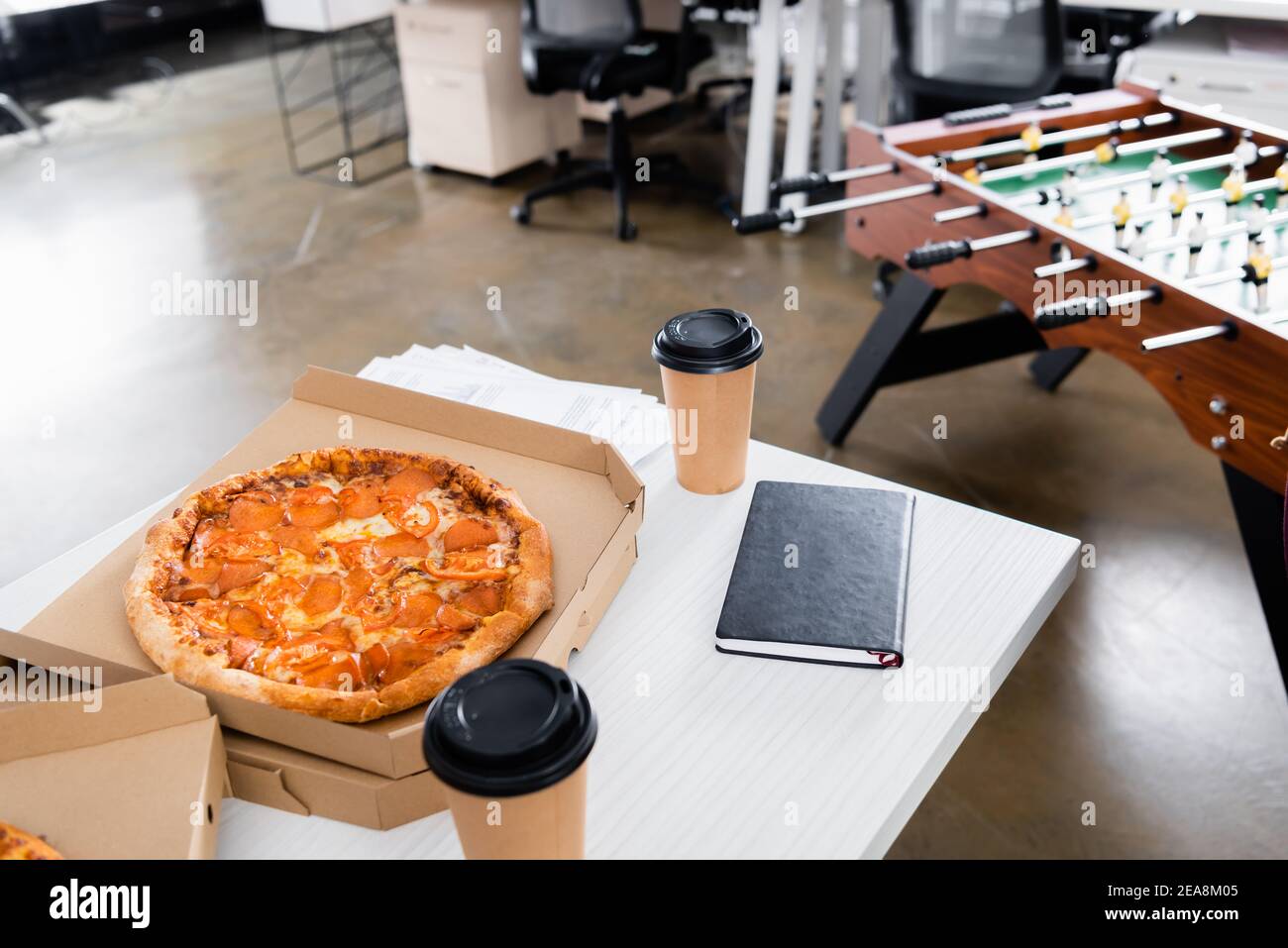 Delicious pizza, takeaway drink and notebook on office table Stock ...
