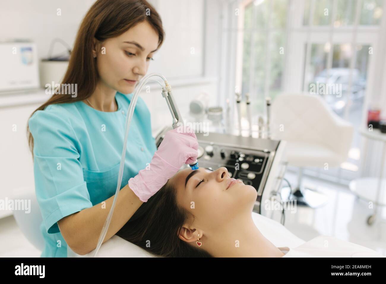 Professional female cosmetologist doing hydrafacial procedure for ...