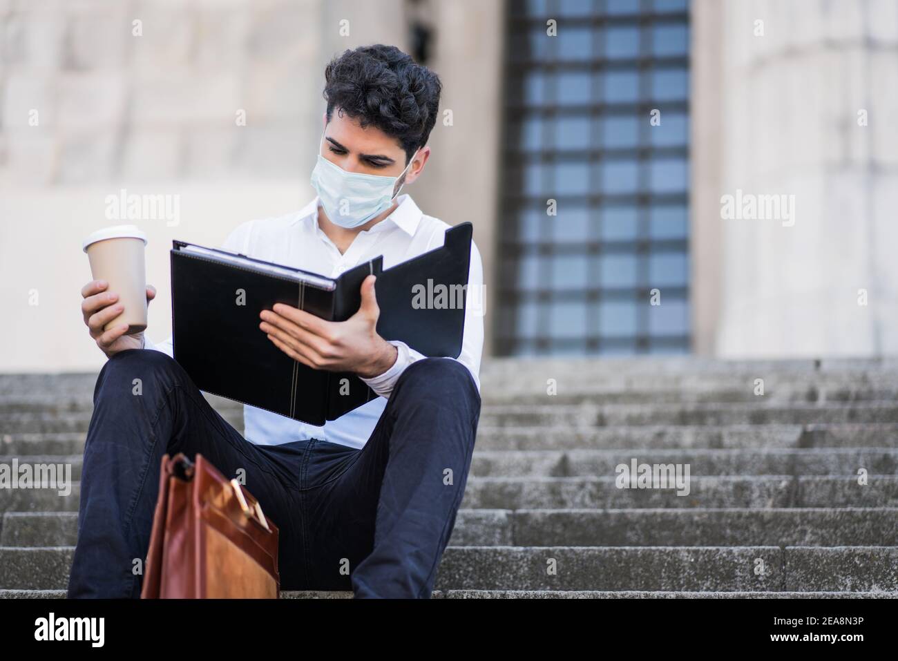 Business man reading files outdoors Stock Photo - Alamy
