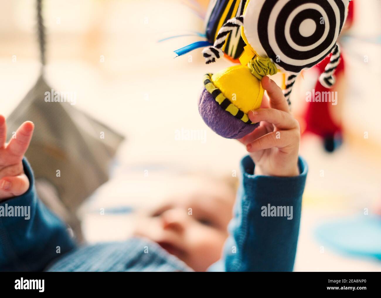 Baby boy exploring mobile toys Stock Photo - Alamy