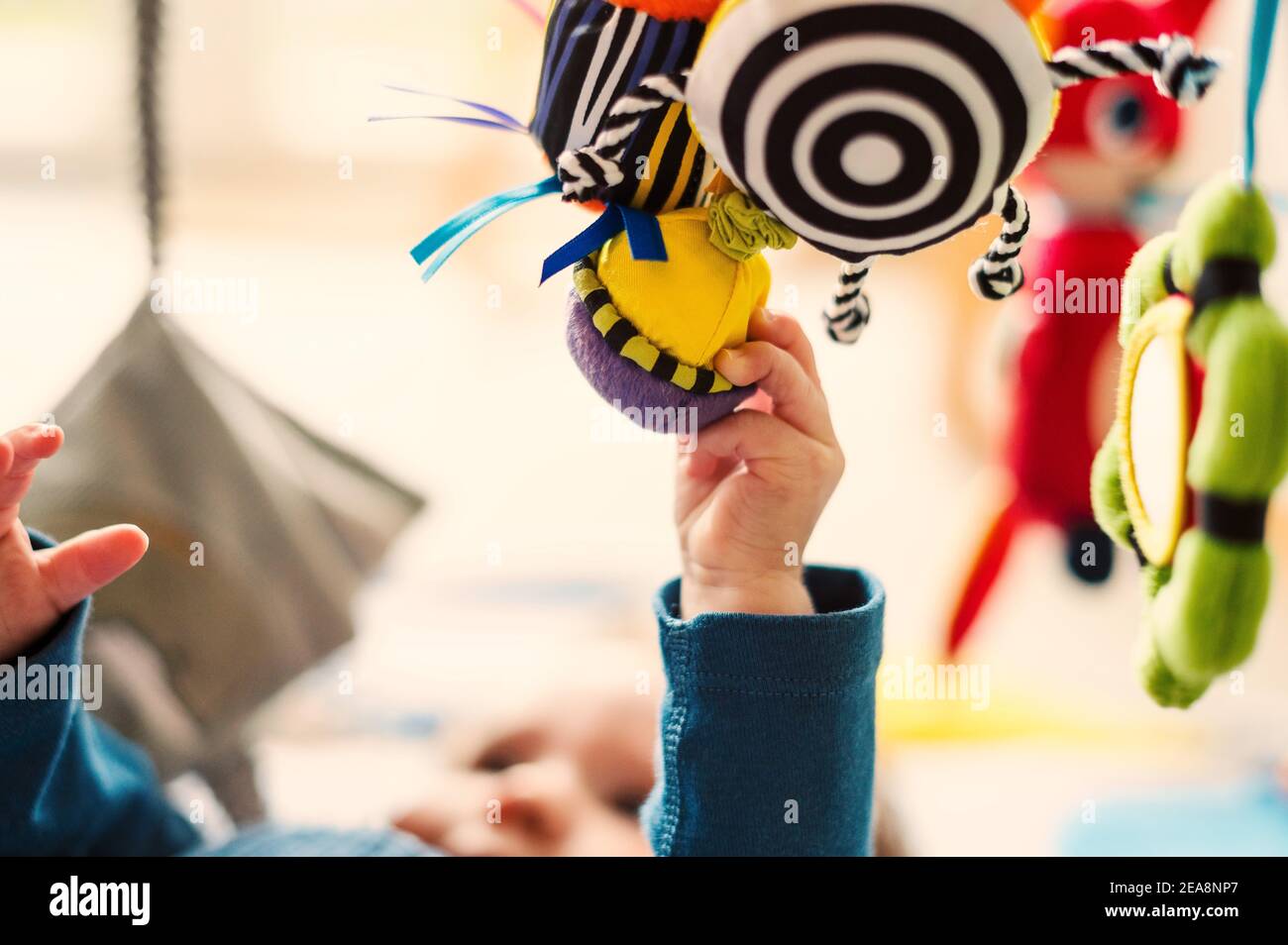 Baby boy exploring mobile toys Stock Photo - Alamy