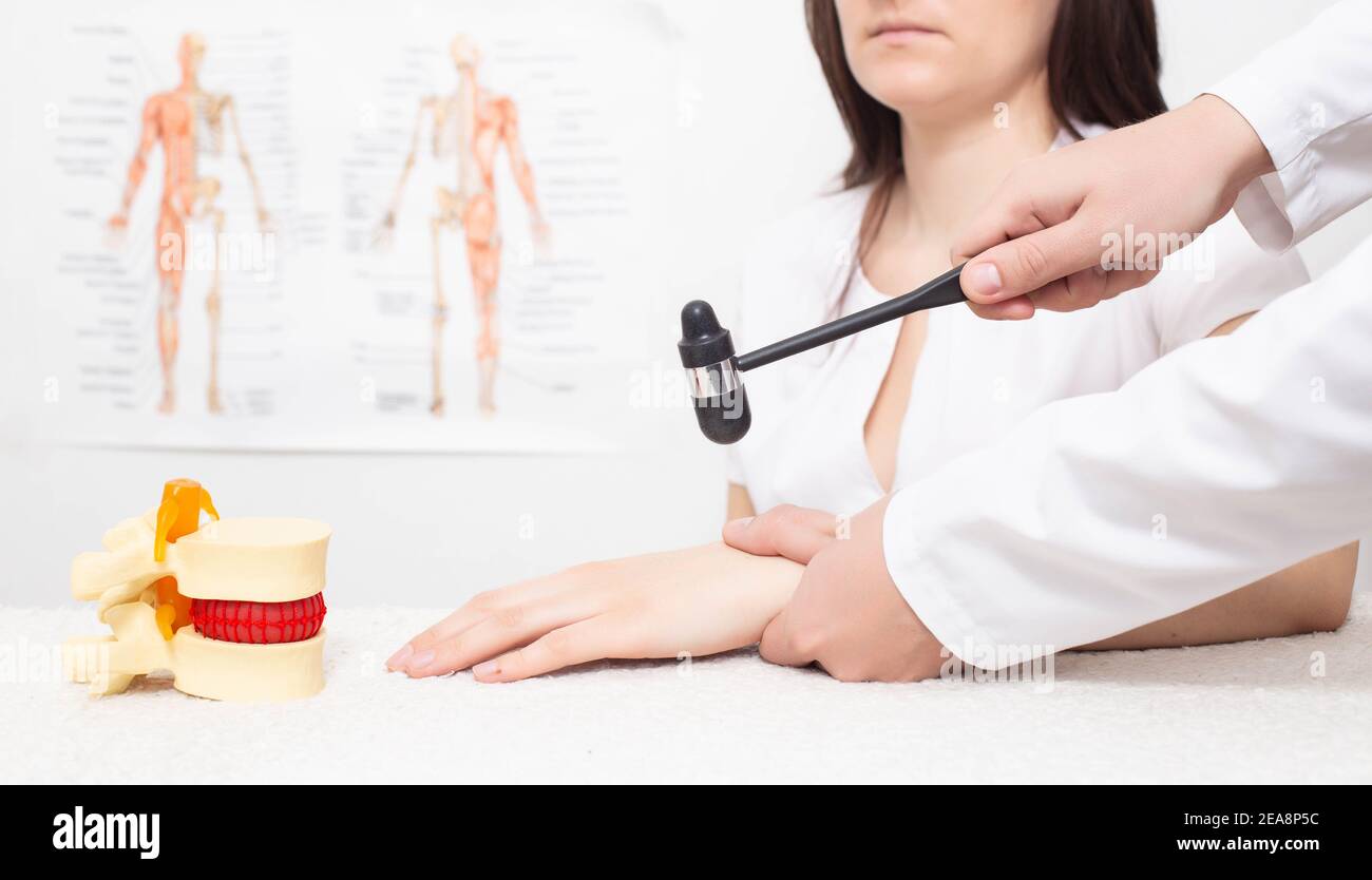 A neurologist doctor checks the brachio radial reflex on the arm of a ...