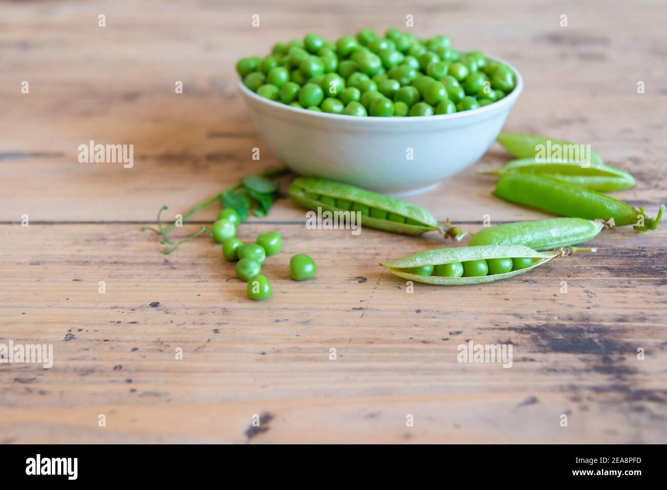 Bowl of fresh green peas with pea pods on wooden rustic table. Fresh ...