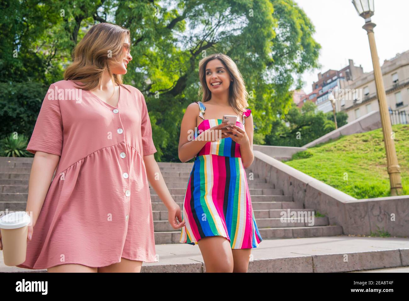 Two friends walking on the street Stock Photo - Alamy