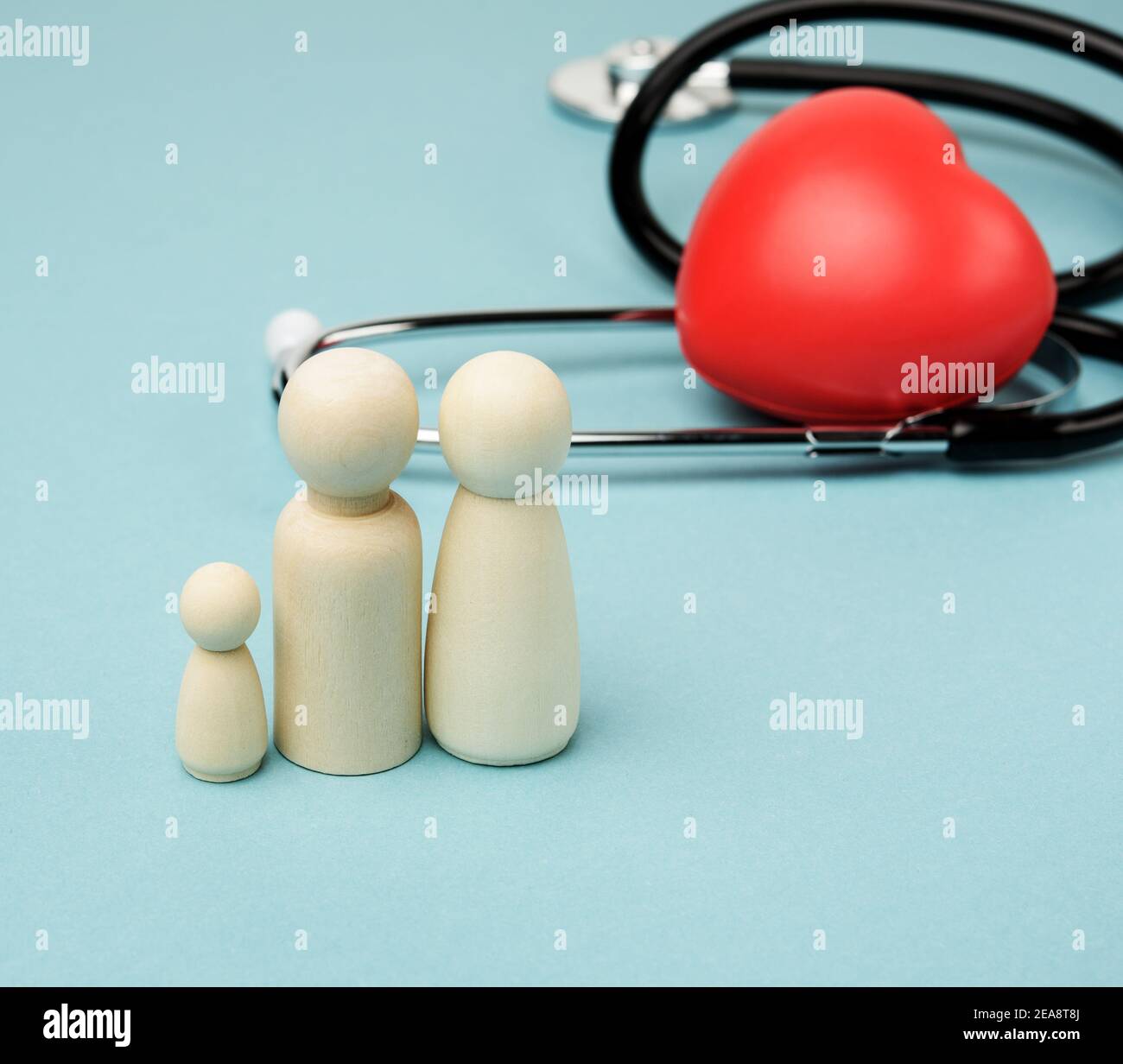 family of wooden figures of men on background of red heart and ...