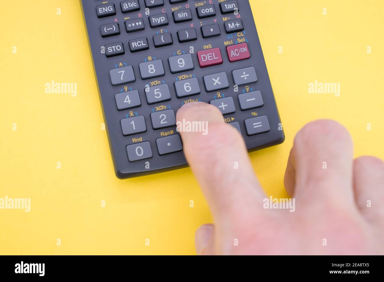 Partial view of a person doing computations on a scientific calculator ...