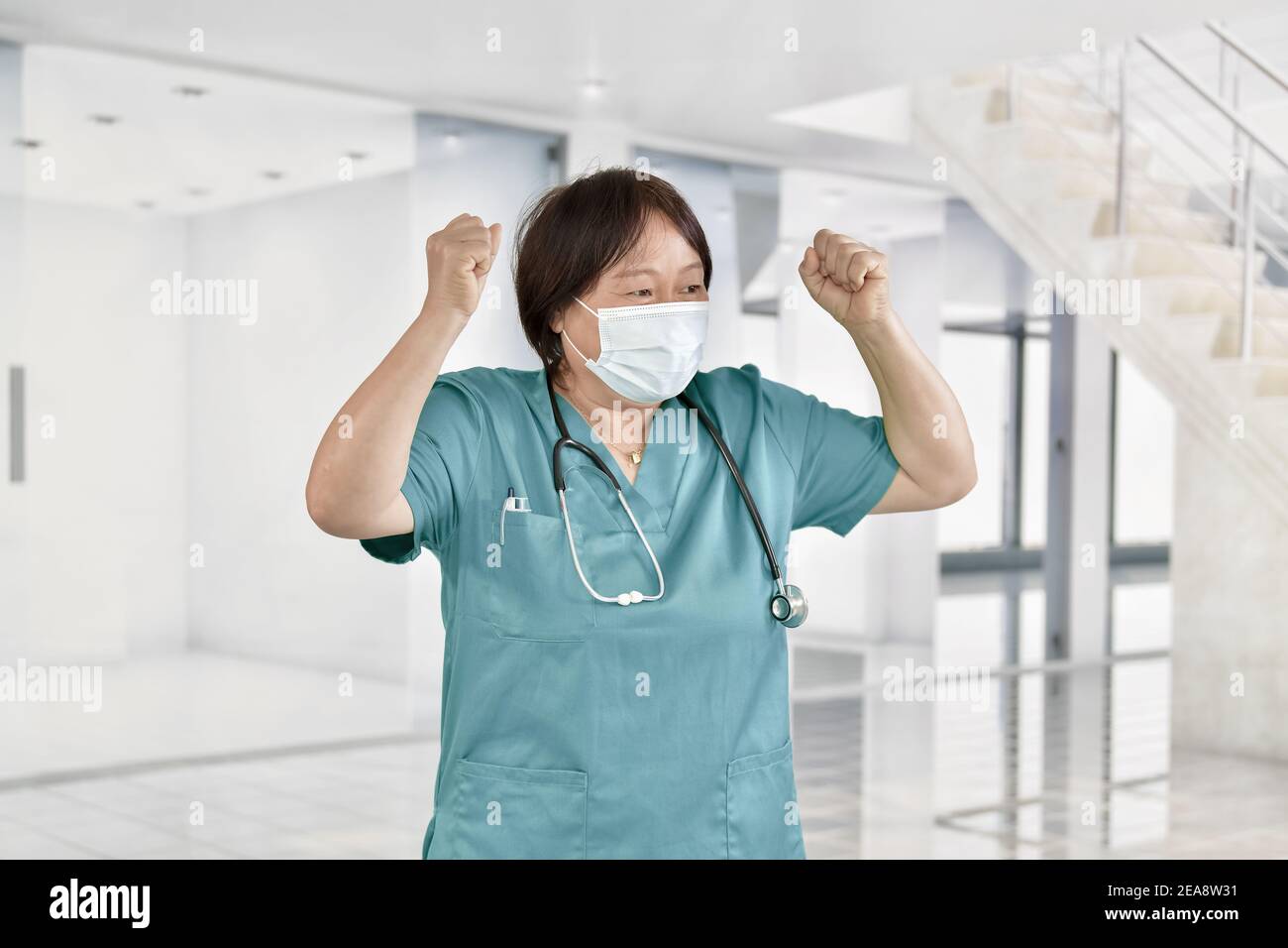 Asian woman doctor raising her arms celebrating Stock Photo - Alamy
