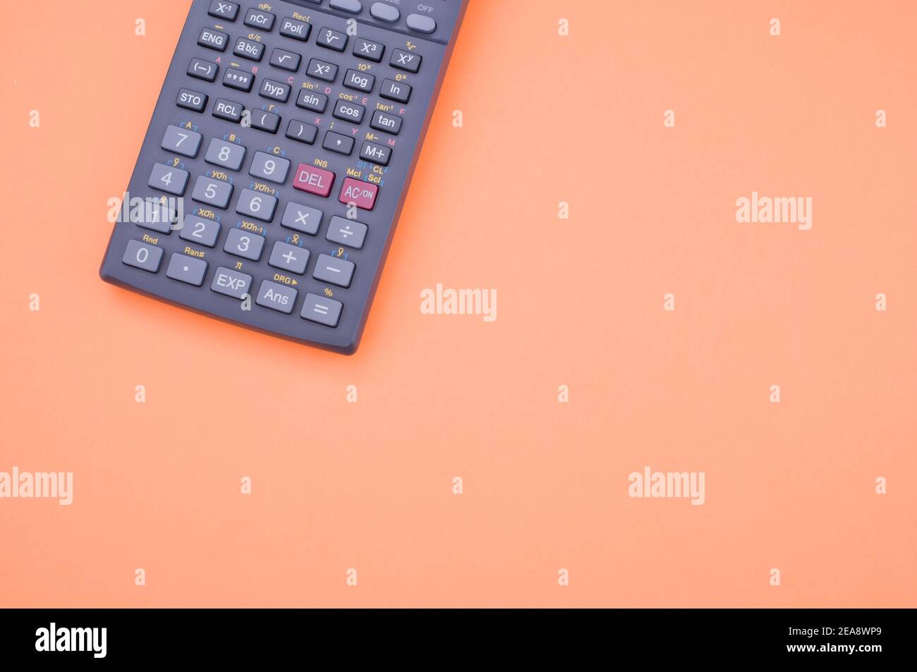 Overhead partial view of a scientific calculator keypad on an orange ...
